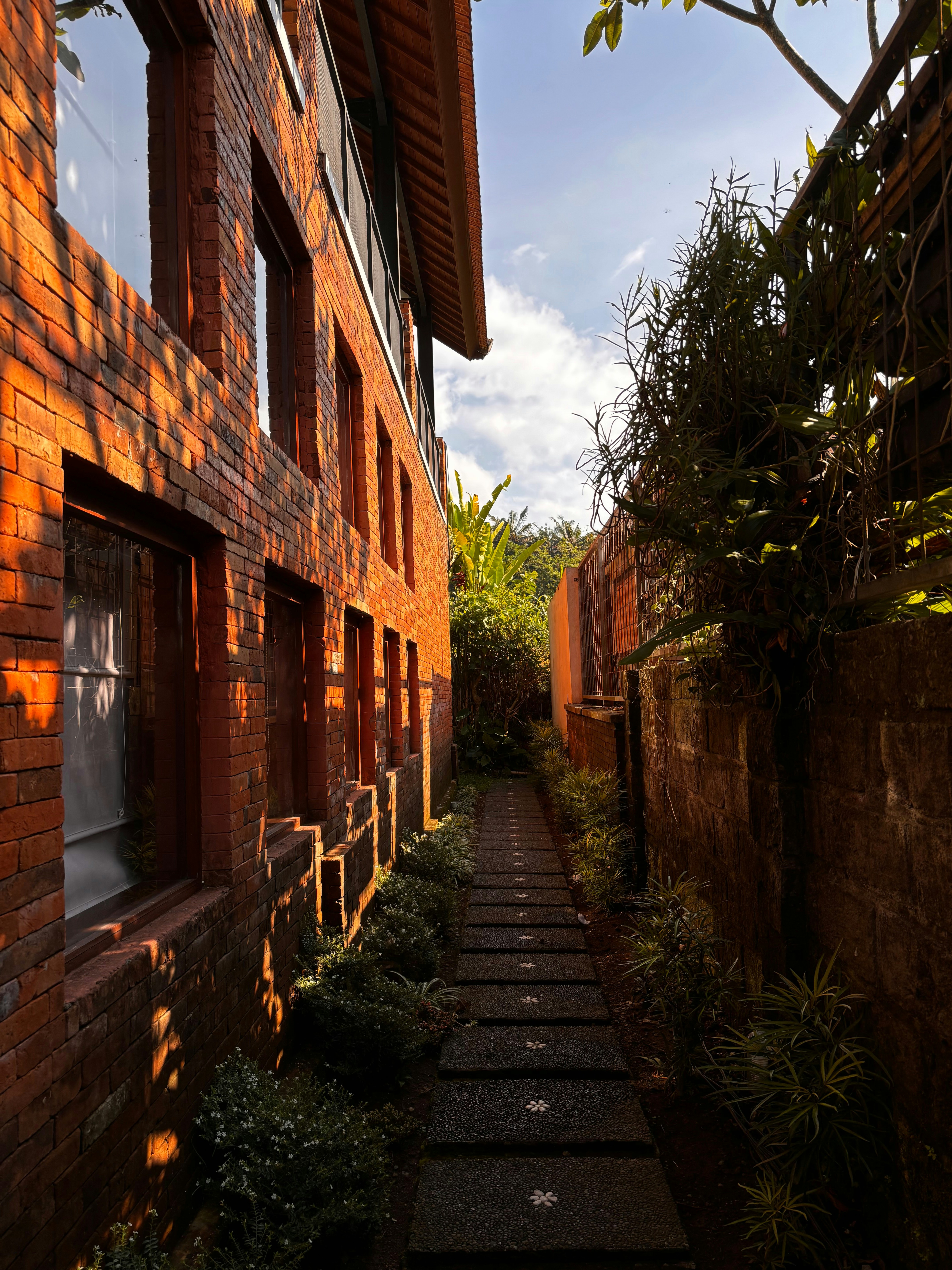 Sunlit Stone Path Between Brick Facades