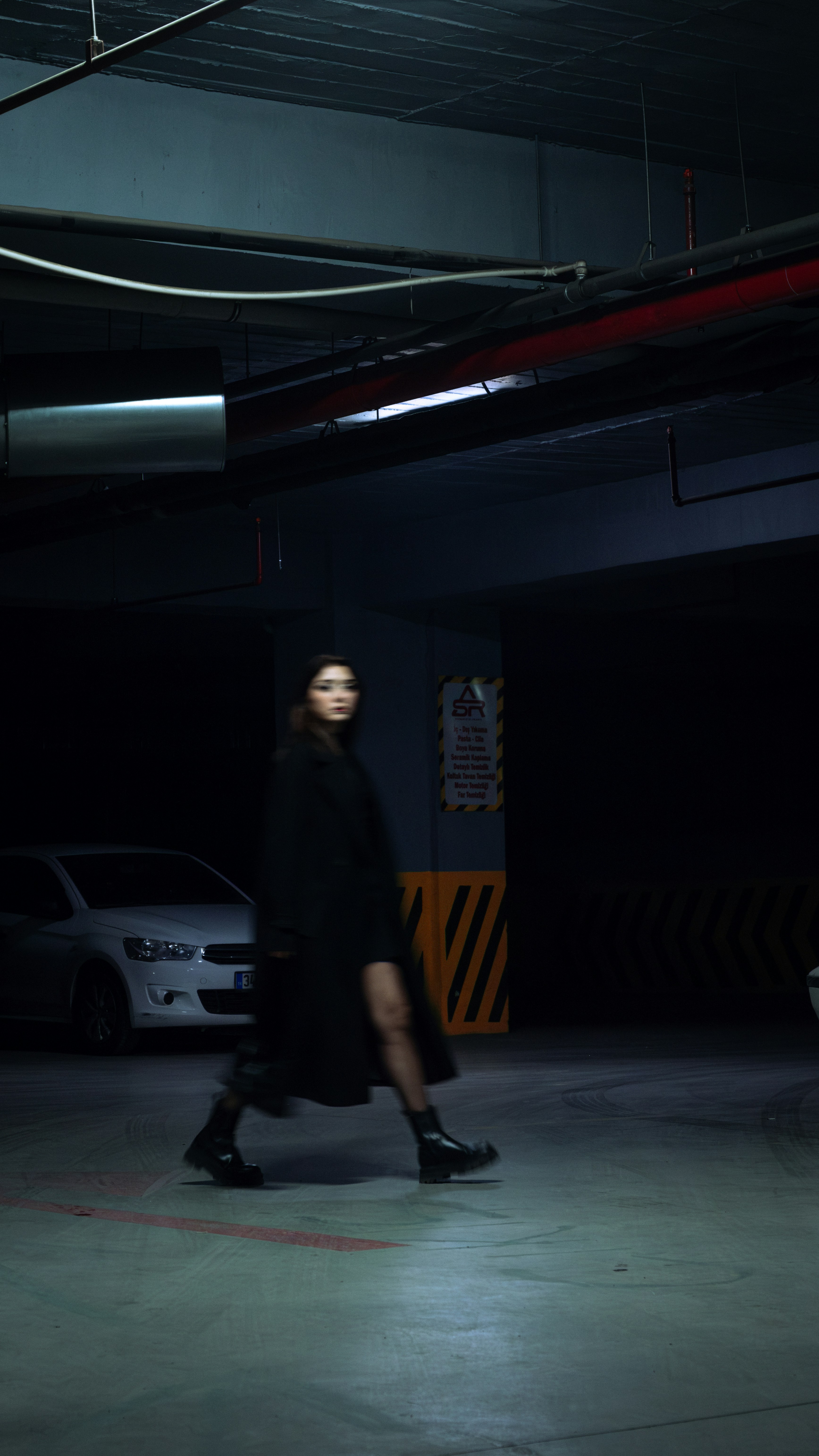 A woman walking in a parking garage at night photo – Free Girl Image on ...