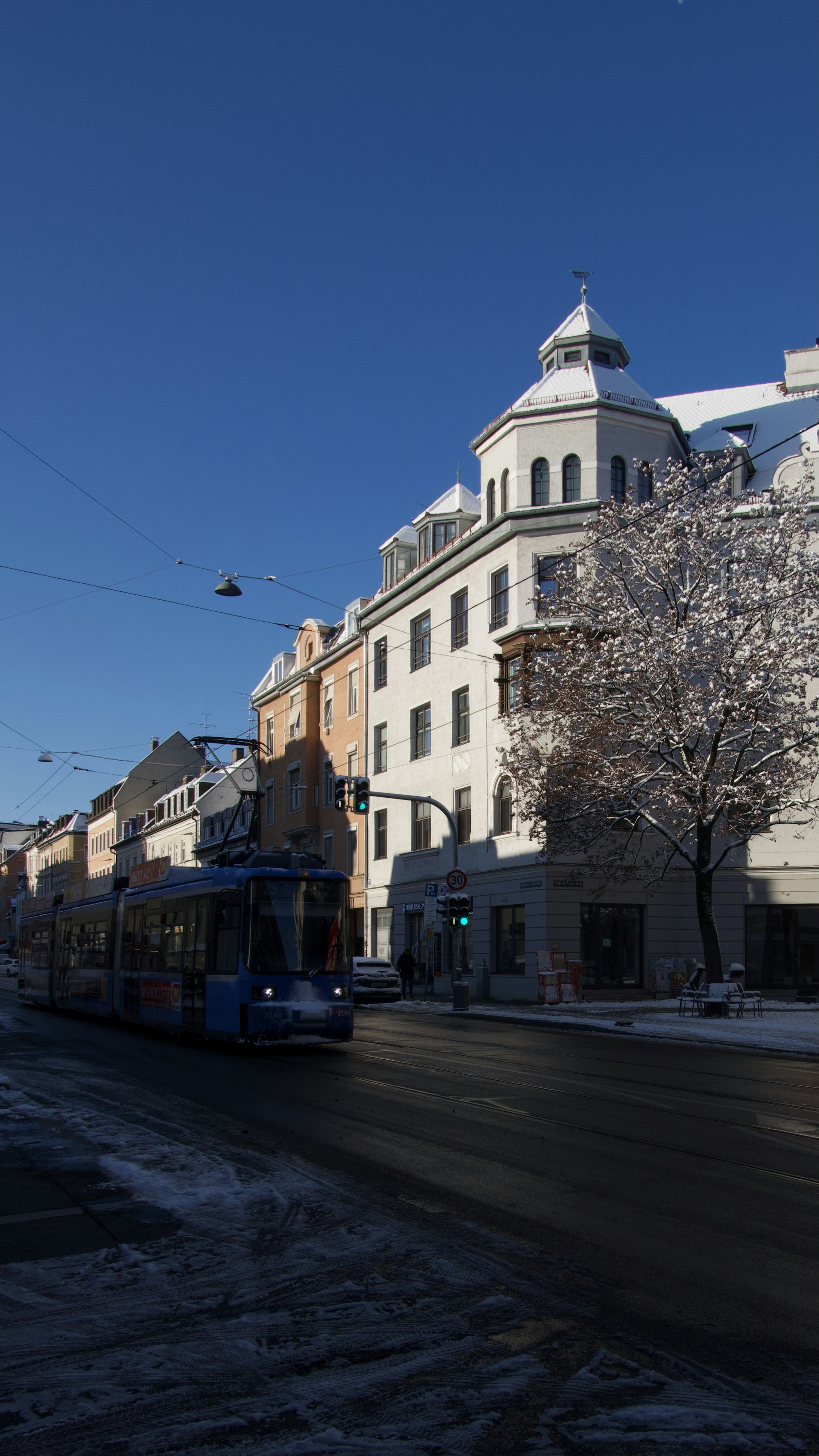 Turreted Winter Facade Under a Clear Sky with a Blue Tram