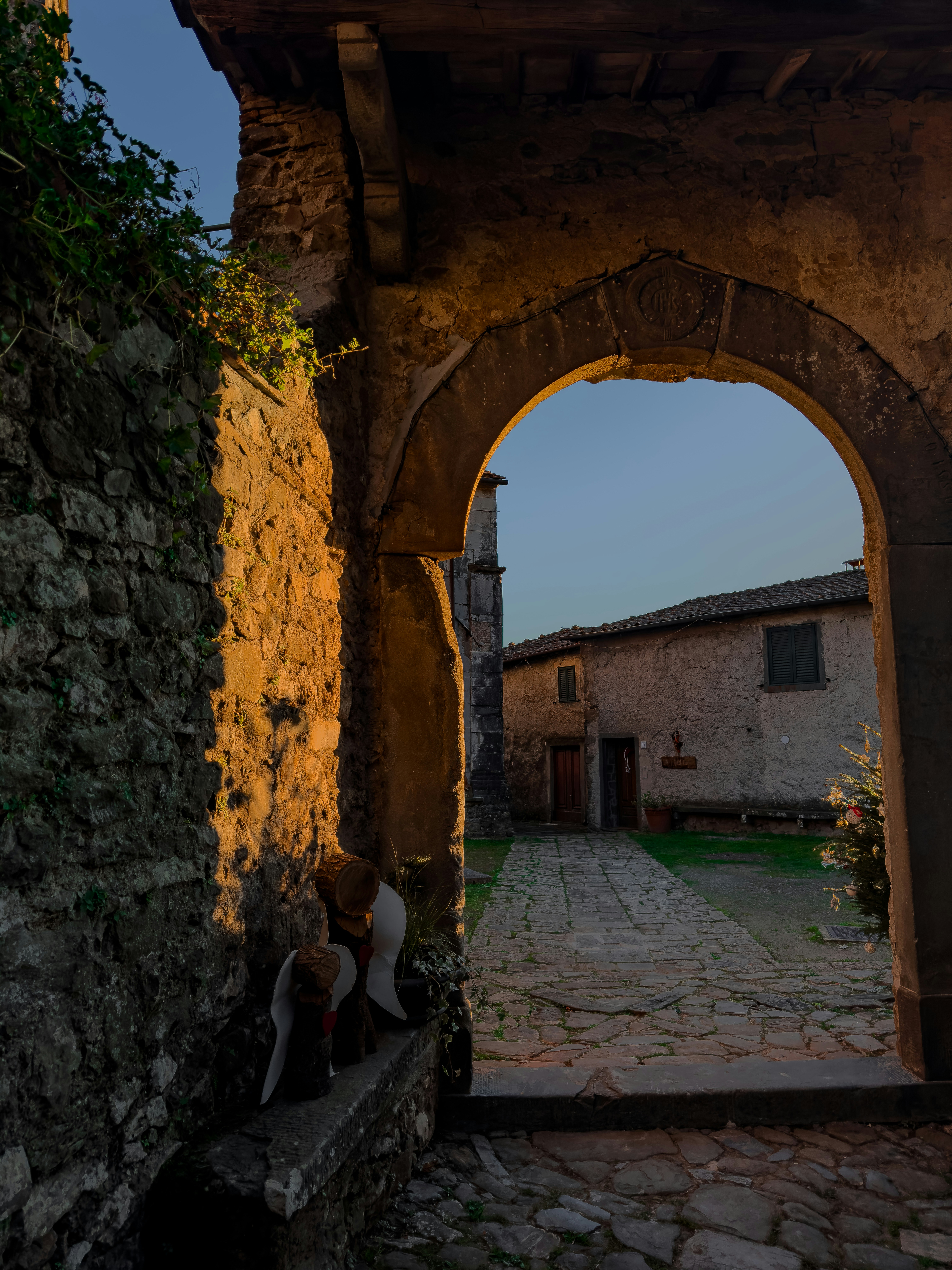 An archway leading to a building with a clock on it photo – Free ...