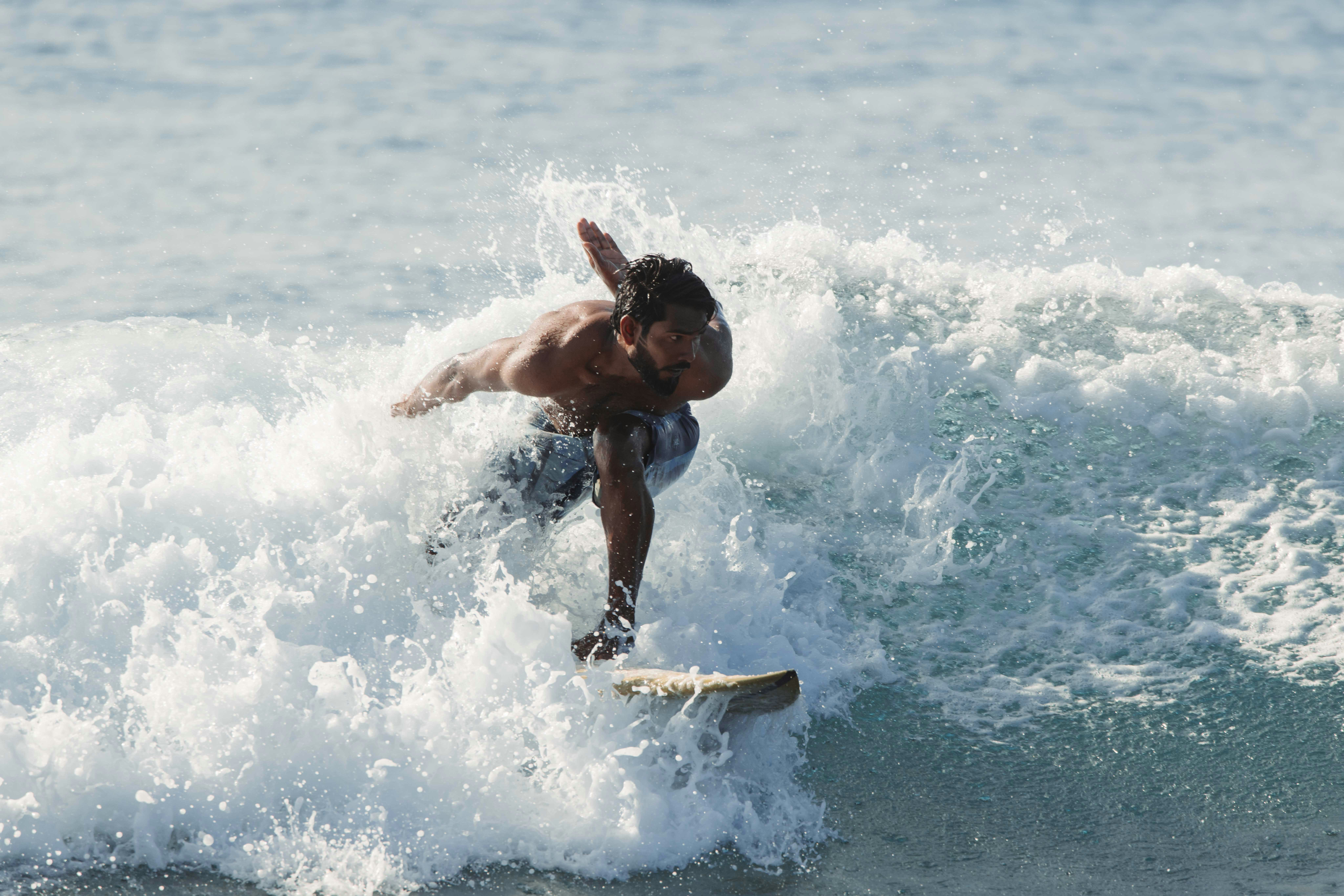 A man riding a wave on top of a surfboard photo – Free Nature Image on ...
