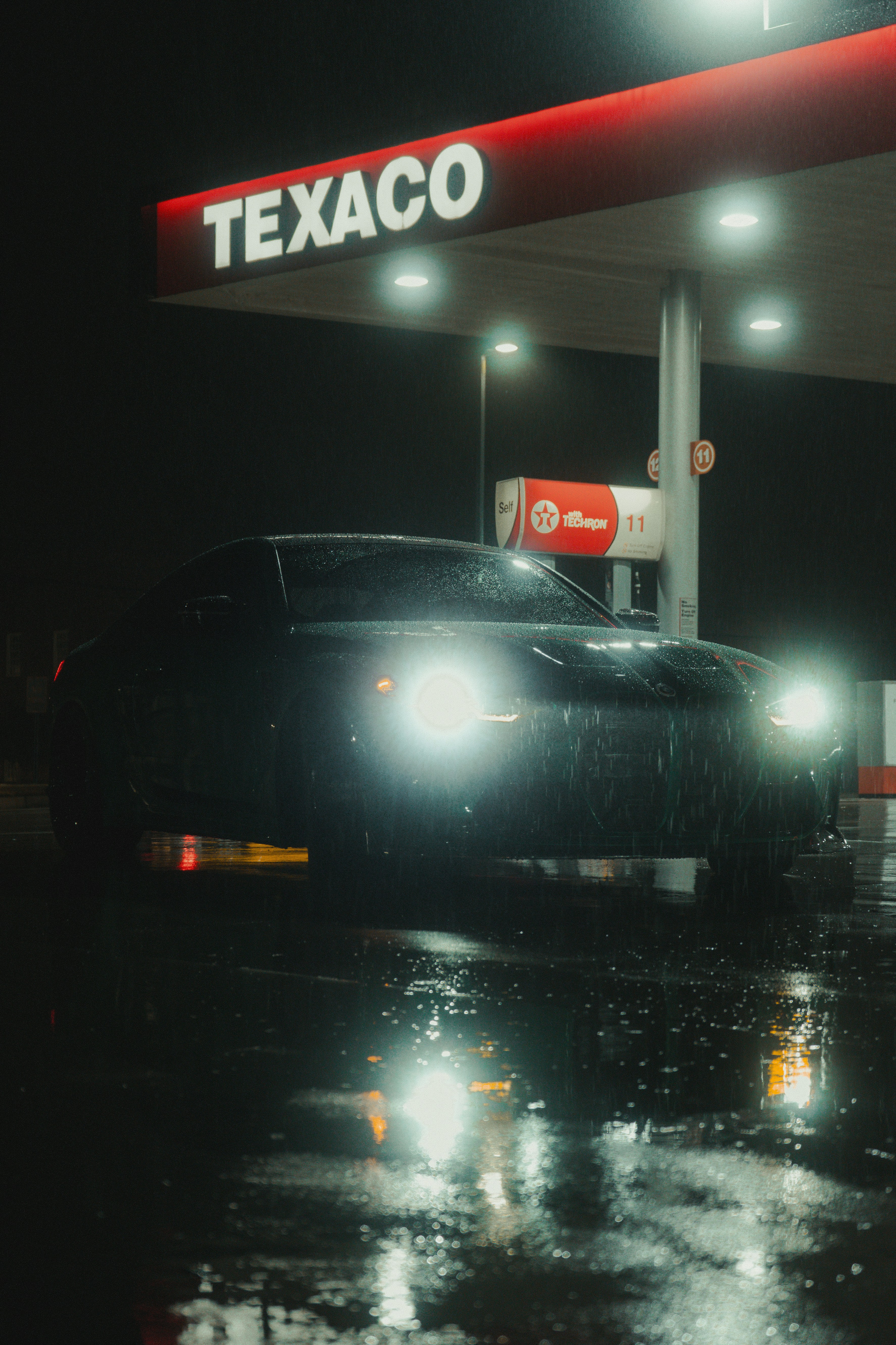 Midnight Rain at Texaco: Headlights Cut Through Neon Reflections