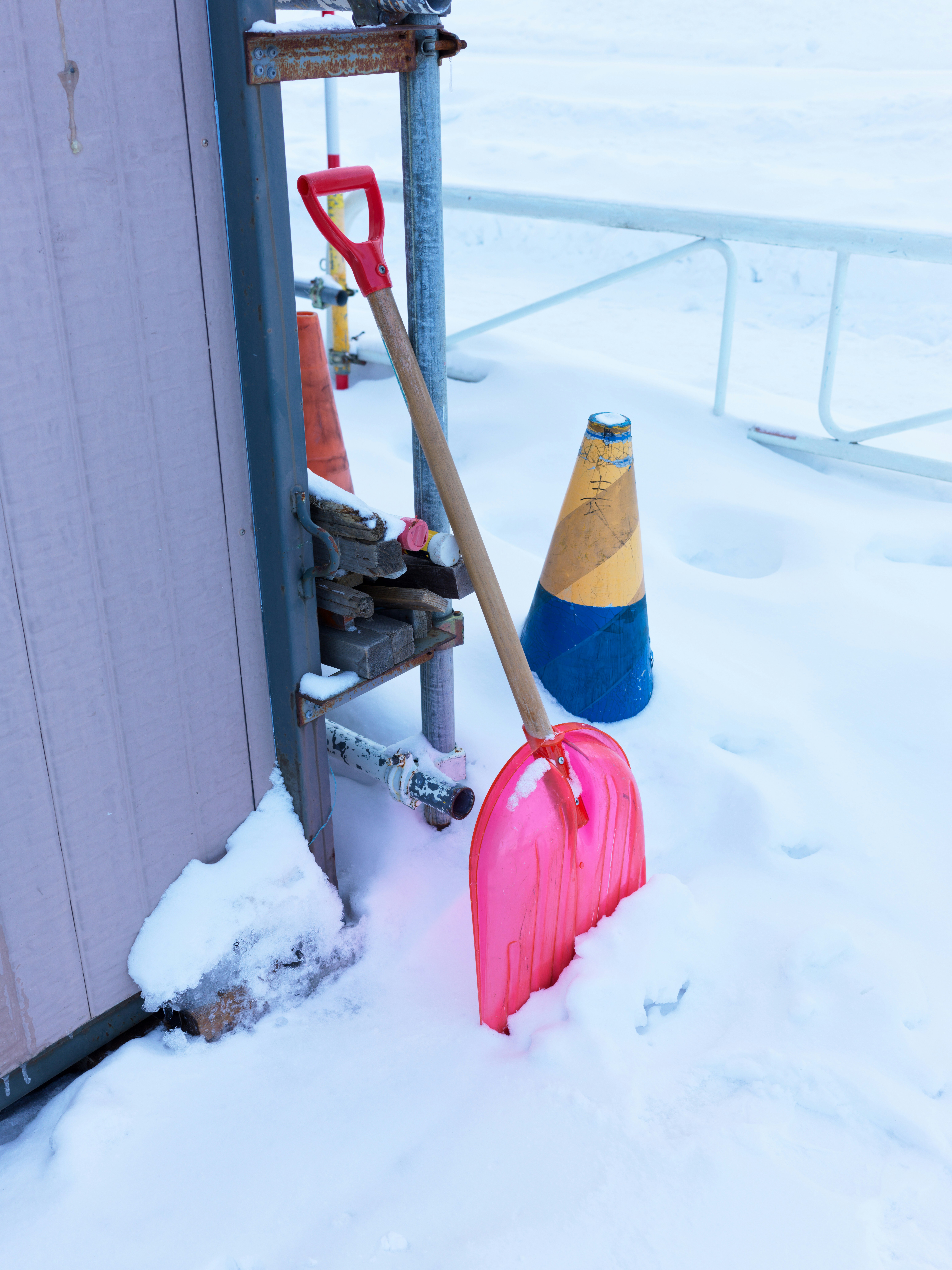 A shovel and a snow cone sitting in the snow