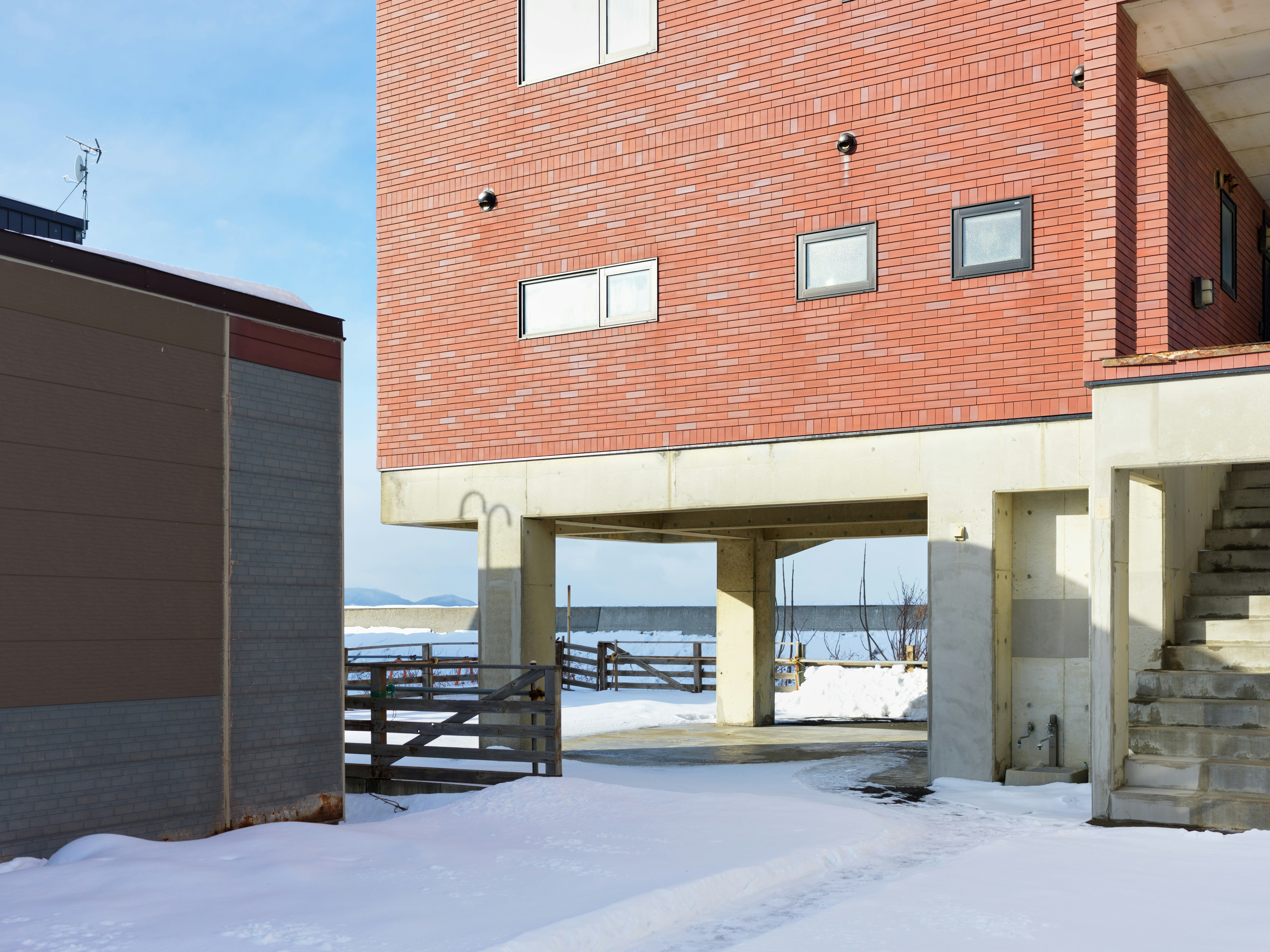 Snowlit Arcade Under a Red Brick Building