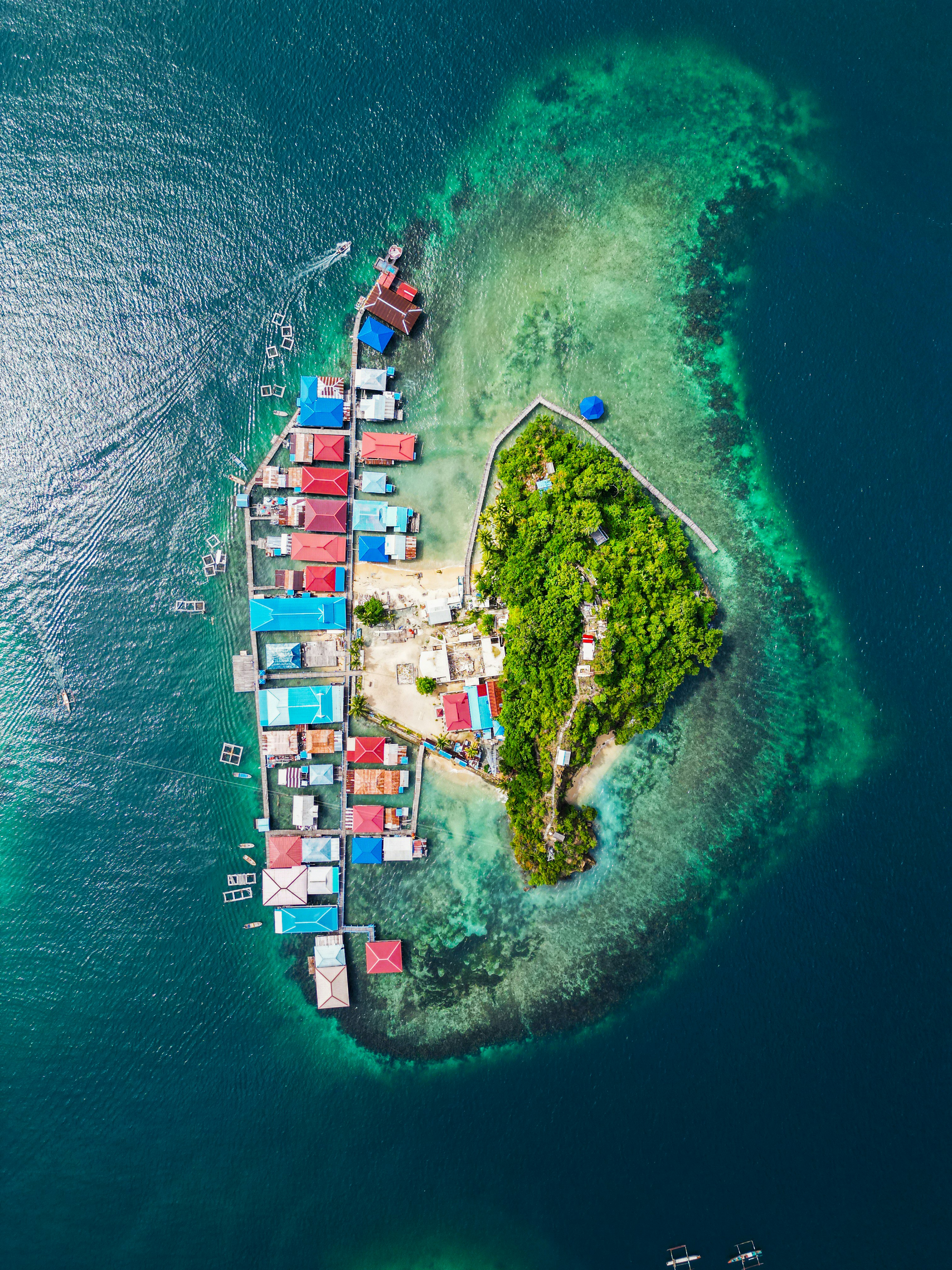 Aerial Hooked on a Crescent: Colorful Village on a Reefed Island