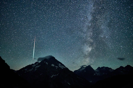 Celestial Cascade Over Moonlit Peaks