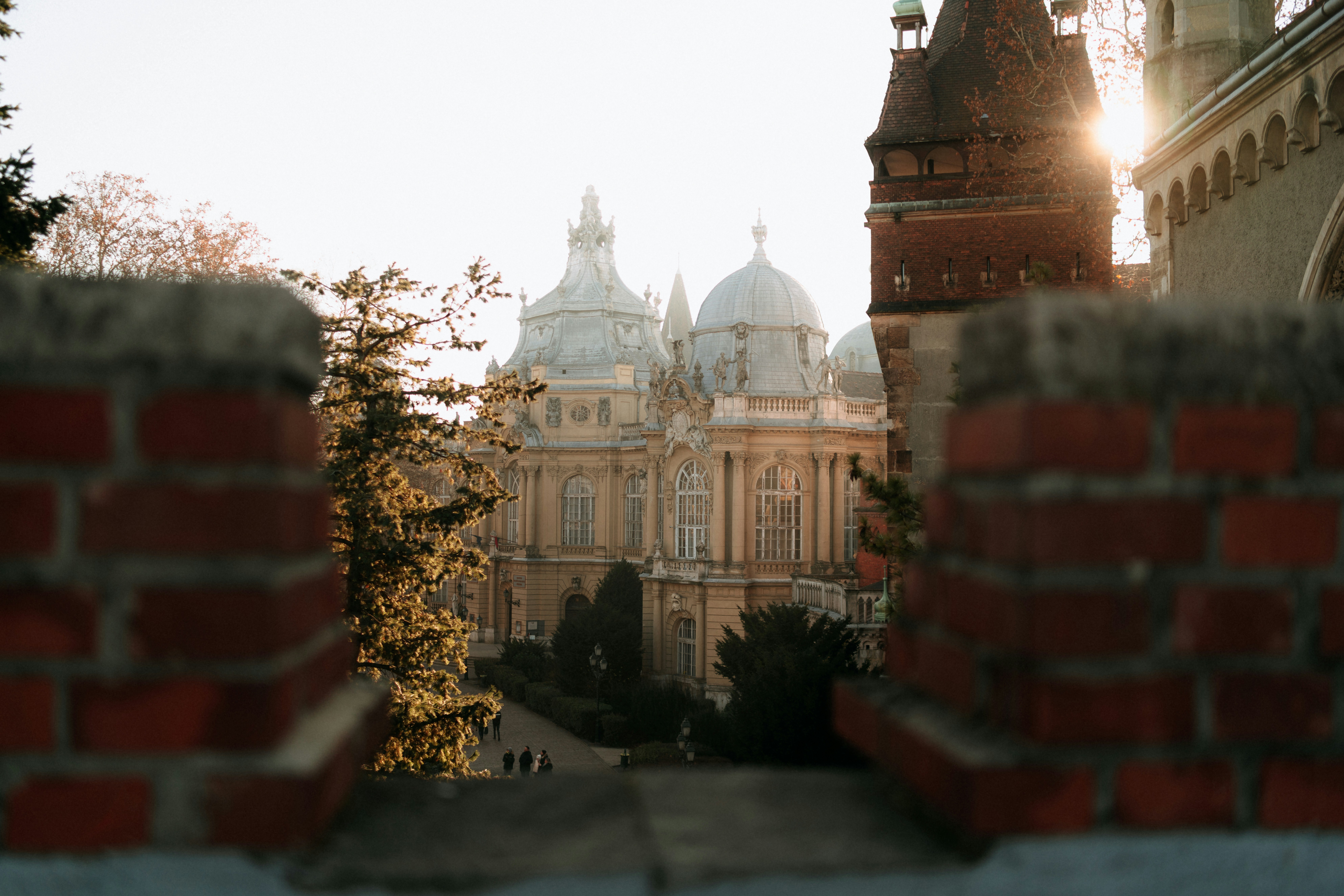 A brick wall with a clock tower in the background photo – Free Budapest ...