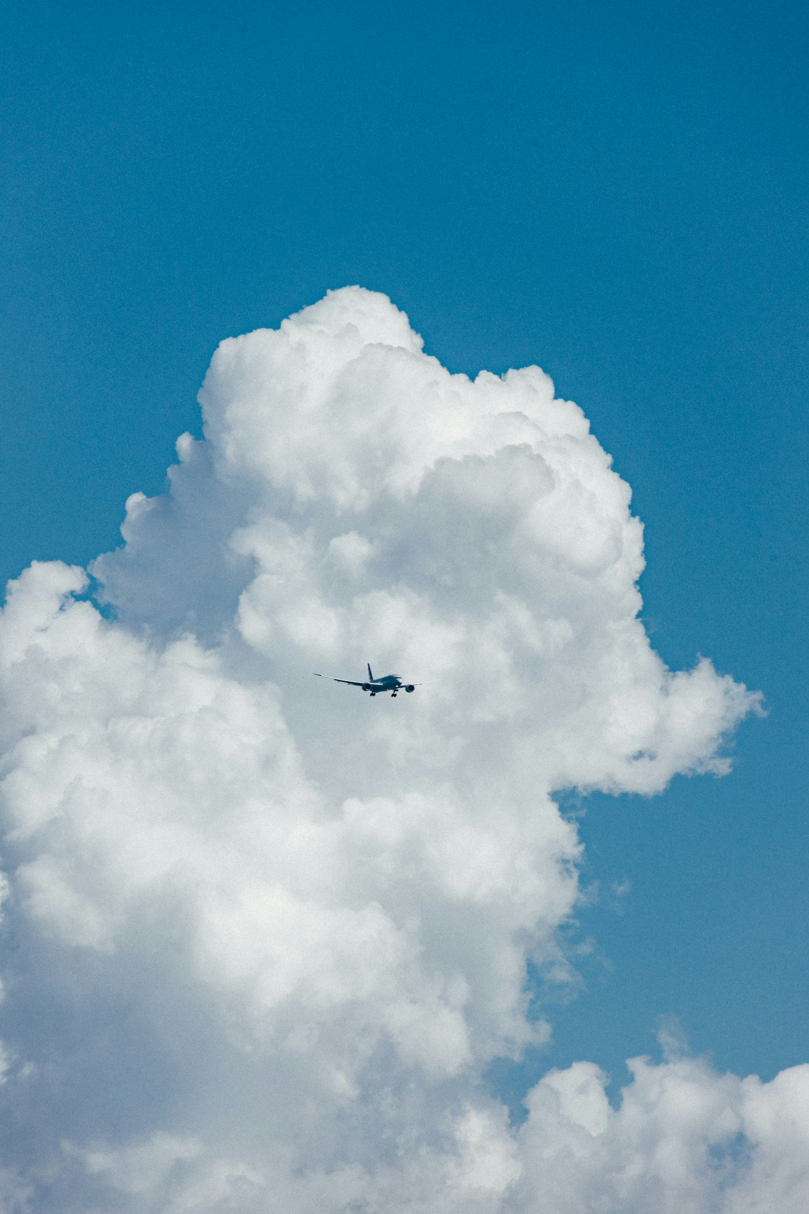 A plane flying through a cloud filled sky photo – Free Cloud Image on ...