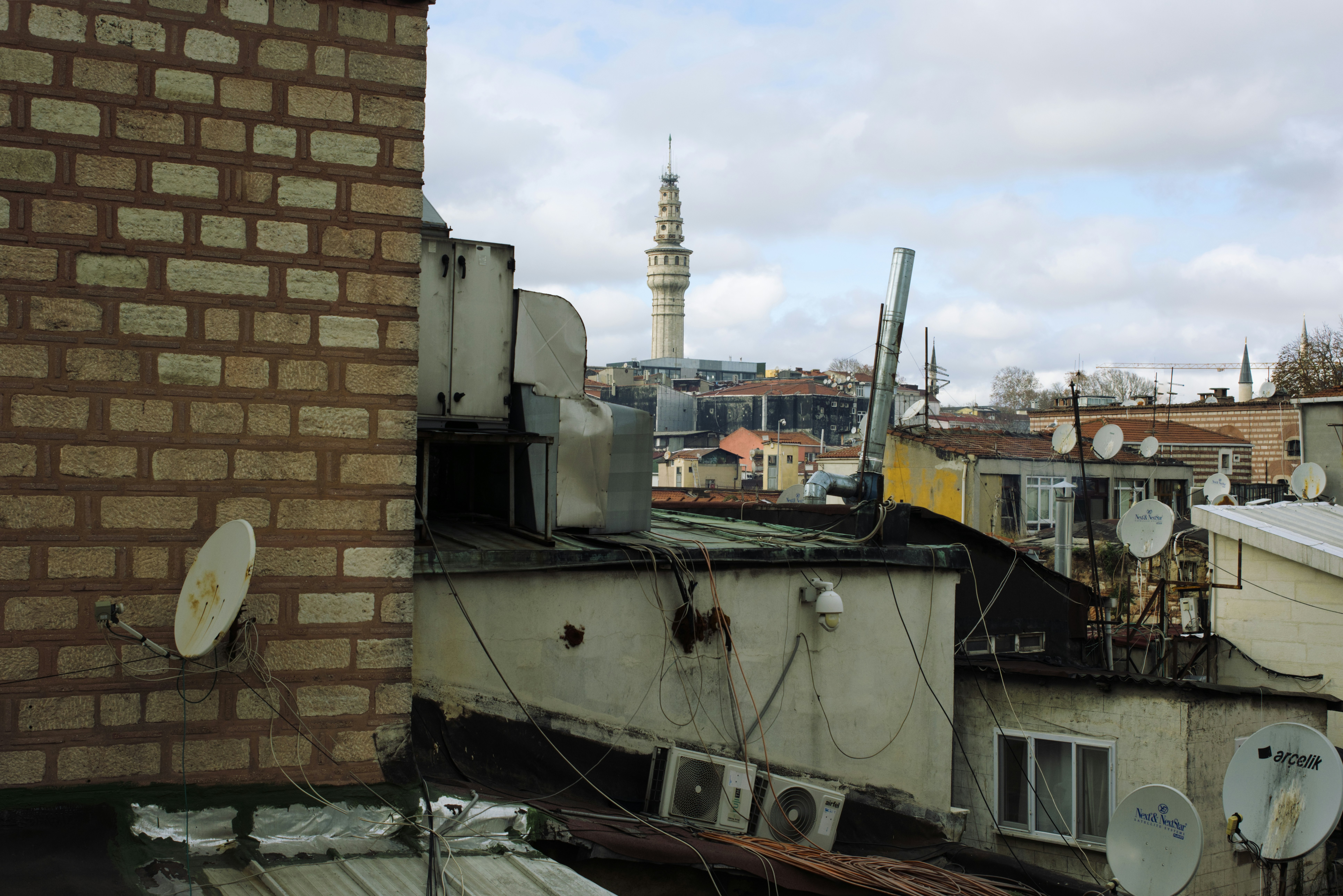 Rooftop Antennas Framing a Distant Minaret in a Quiet Cityscape