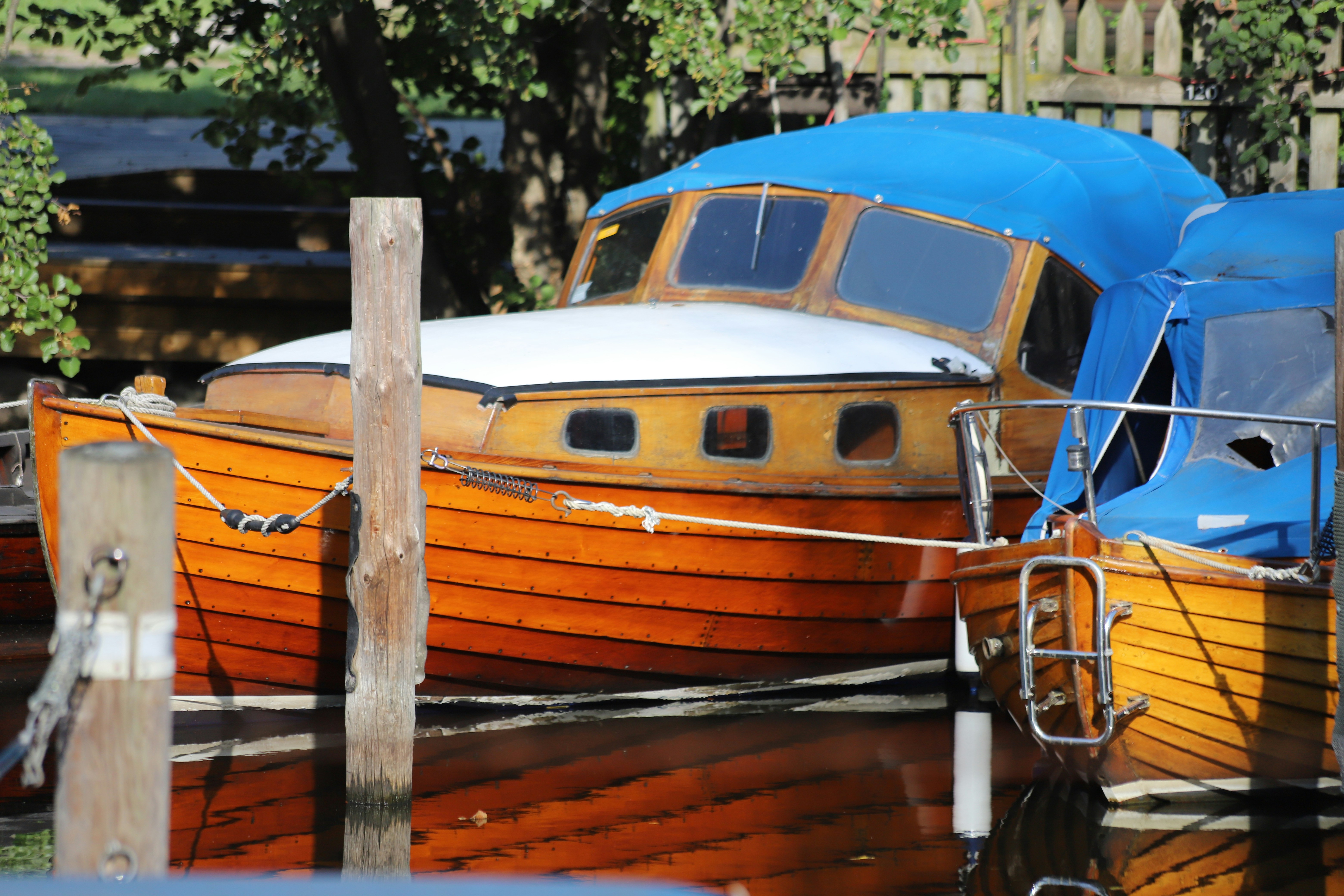 Orange-Wood Cruiser Under Azure Canopy, Framed by a Quiet Water Mirror