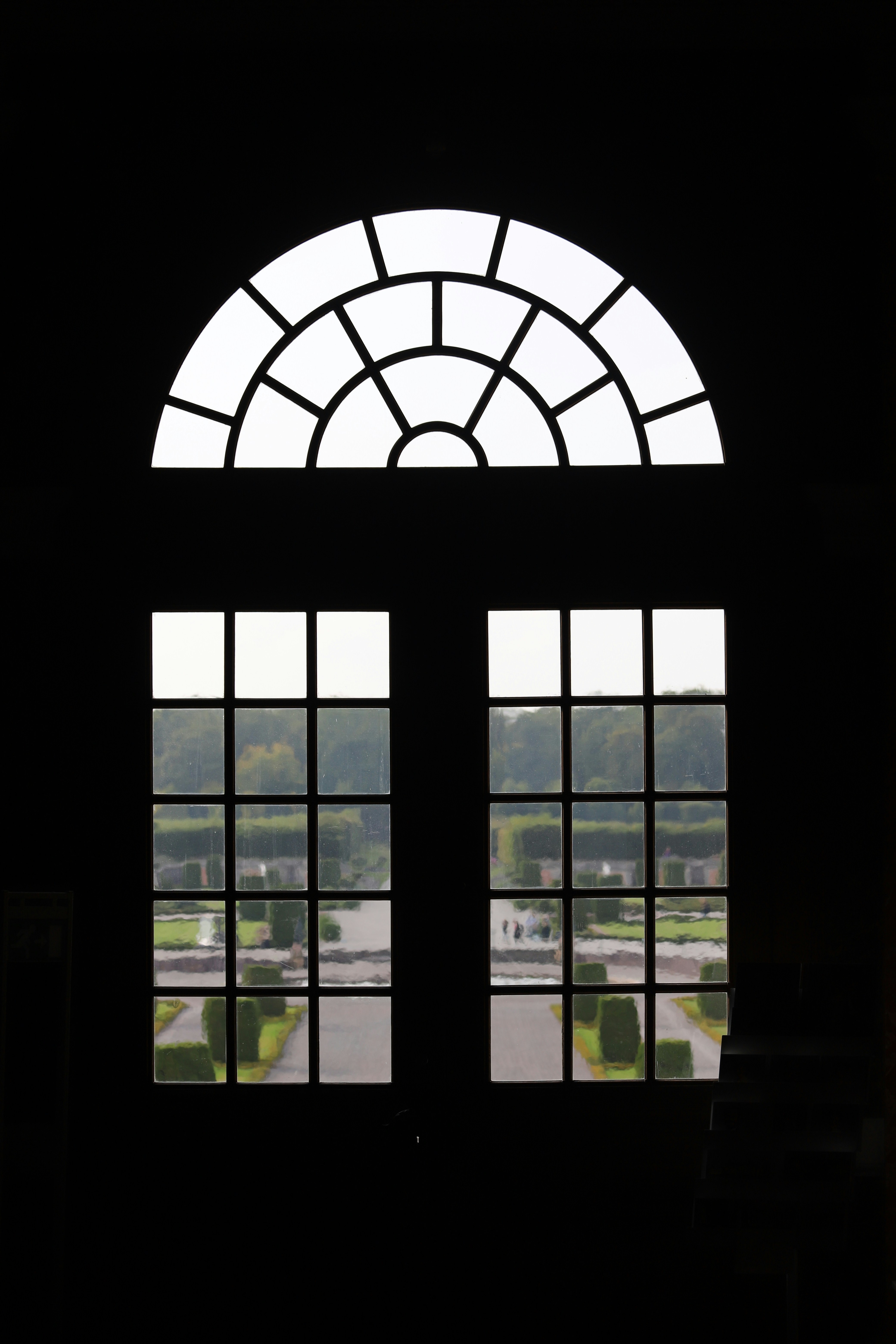 Archlight Over Darkness: Garden View Framed by a Grand Window