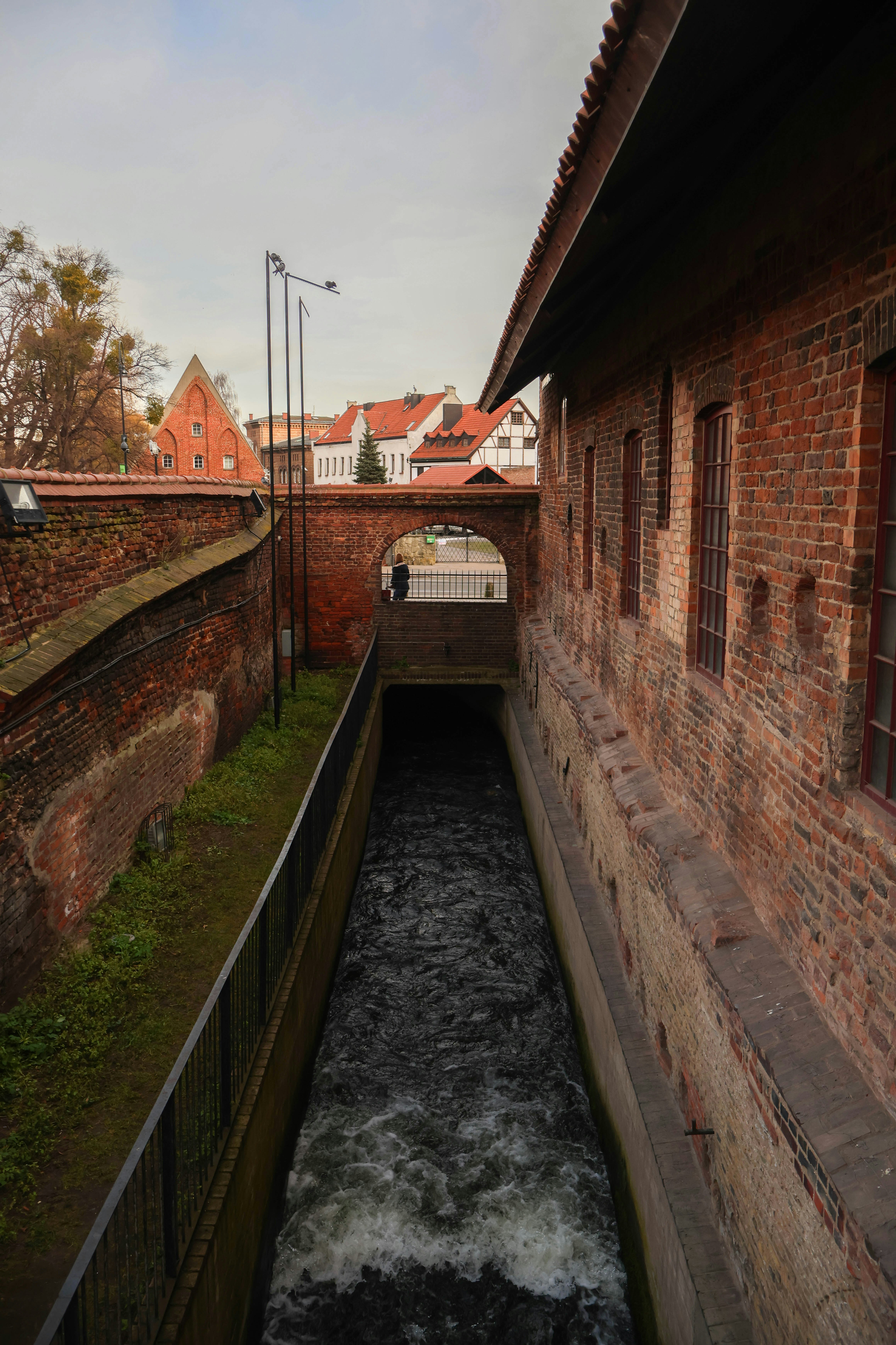 Archway Corridor: A Brick Canal Leading to a Distant Town