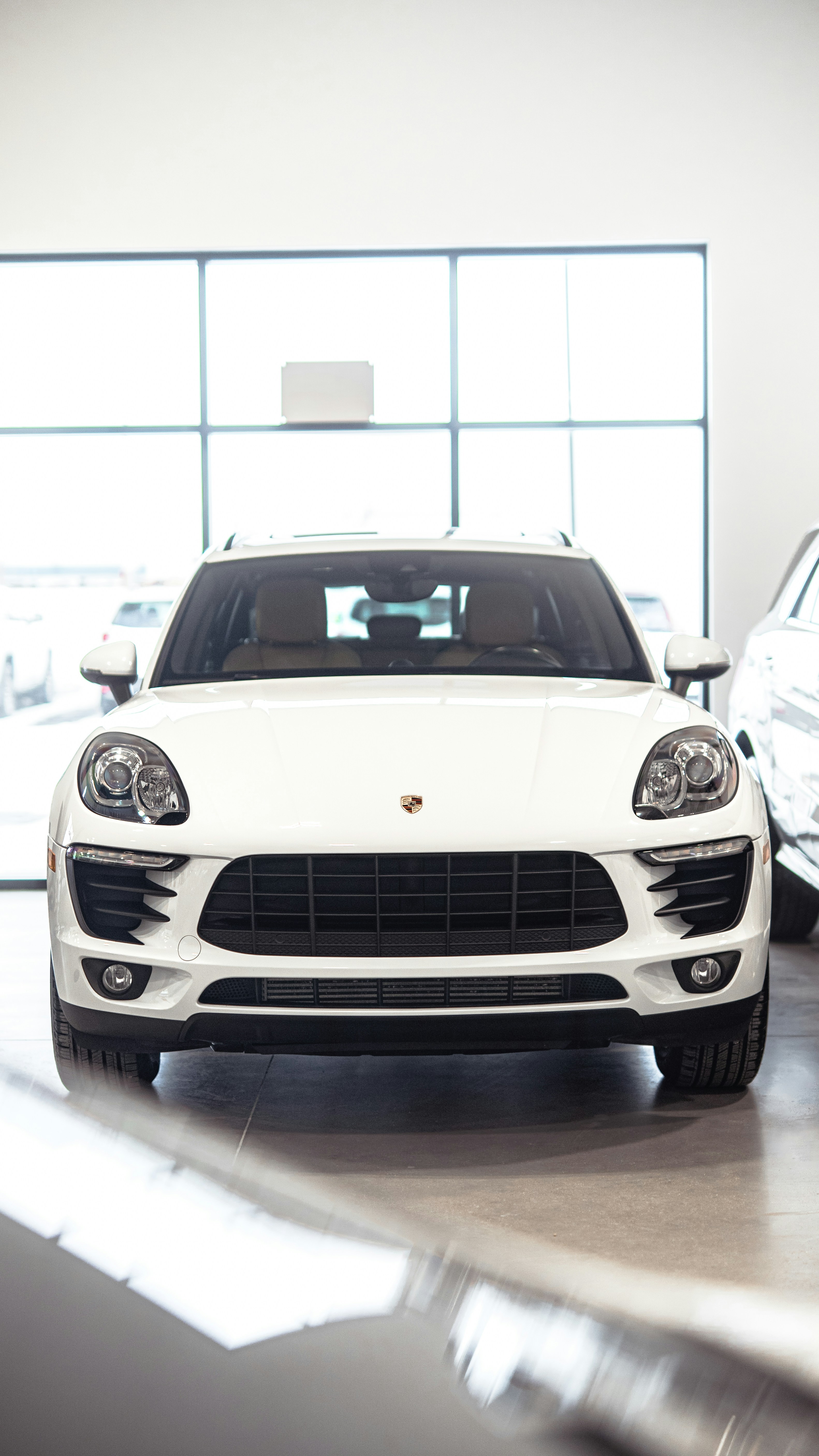 A white porsche cayen is parked in a showroom photo – Free Headlights ...