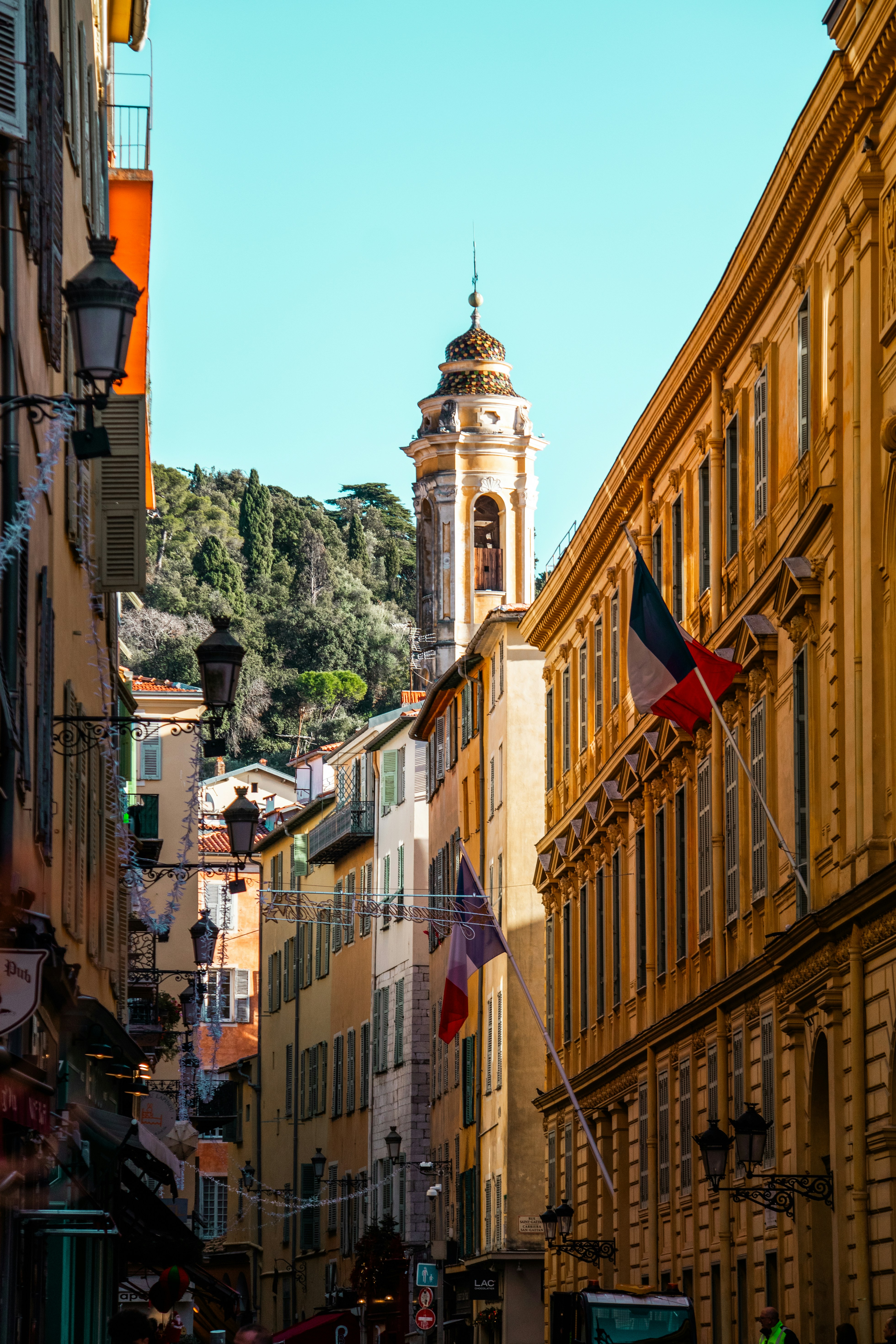 A narrow city street lined with tall buildings photo – Free Building ...