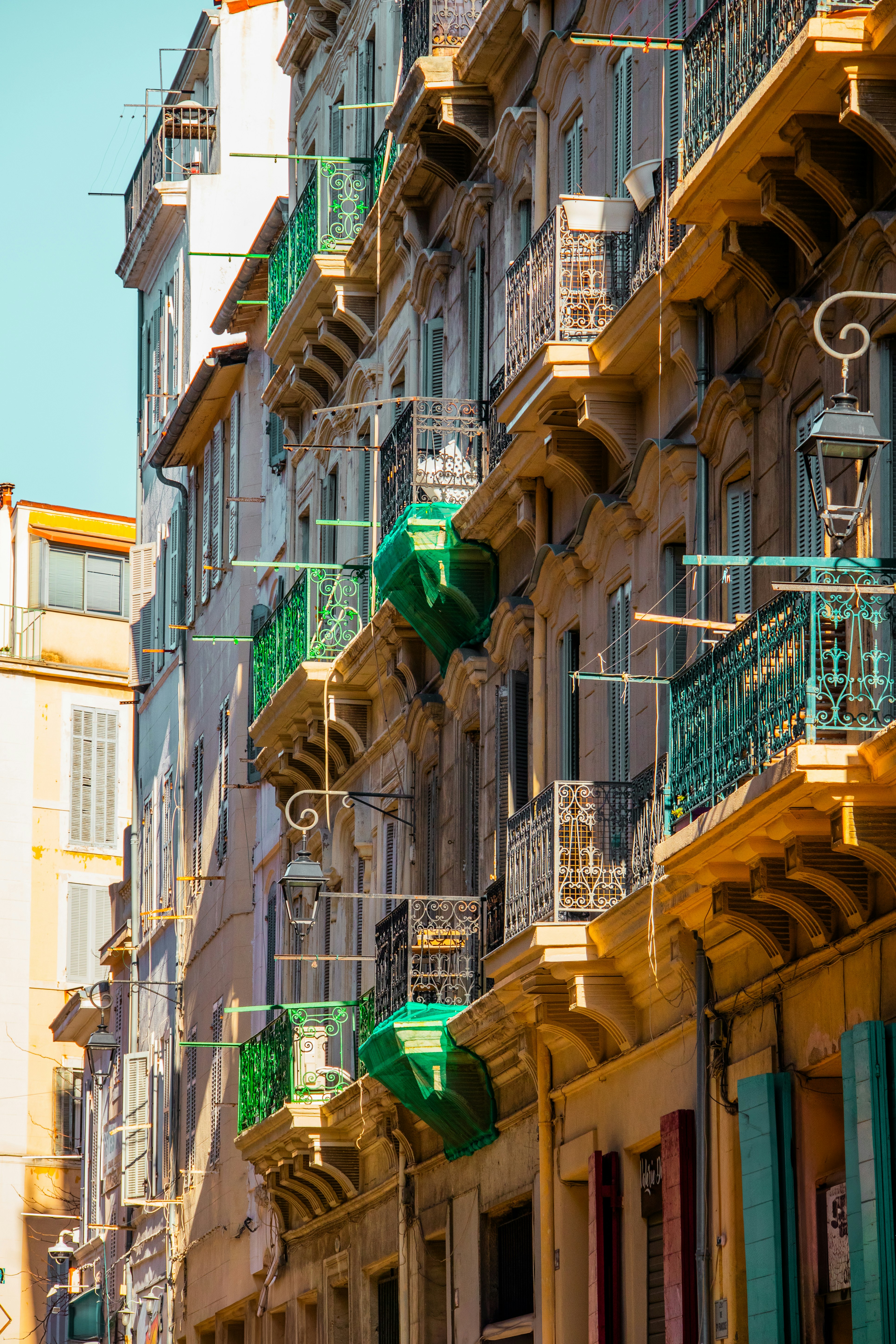 A row of buildings with balconies and green balconies photo – Free City ...