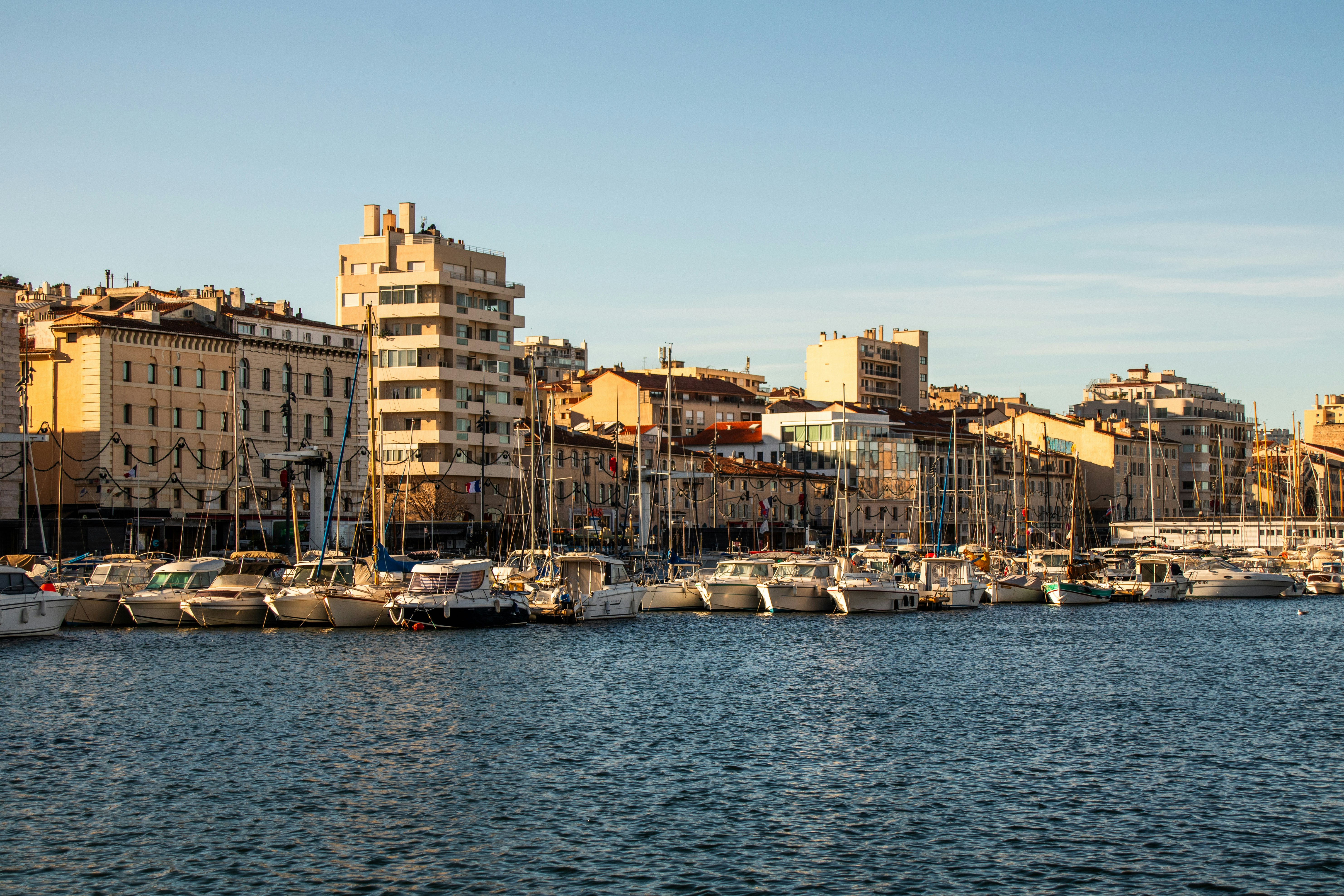 A harbor filled with lots of boats next to tall buildings photo – Free ...
