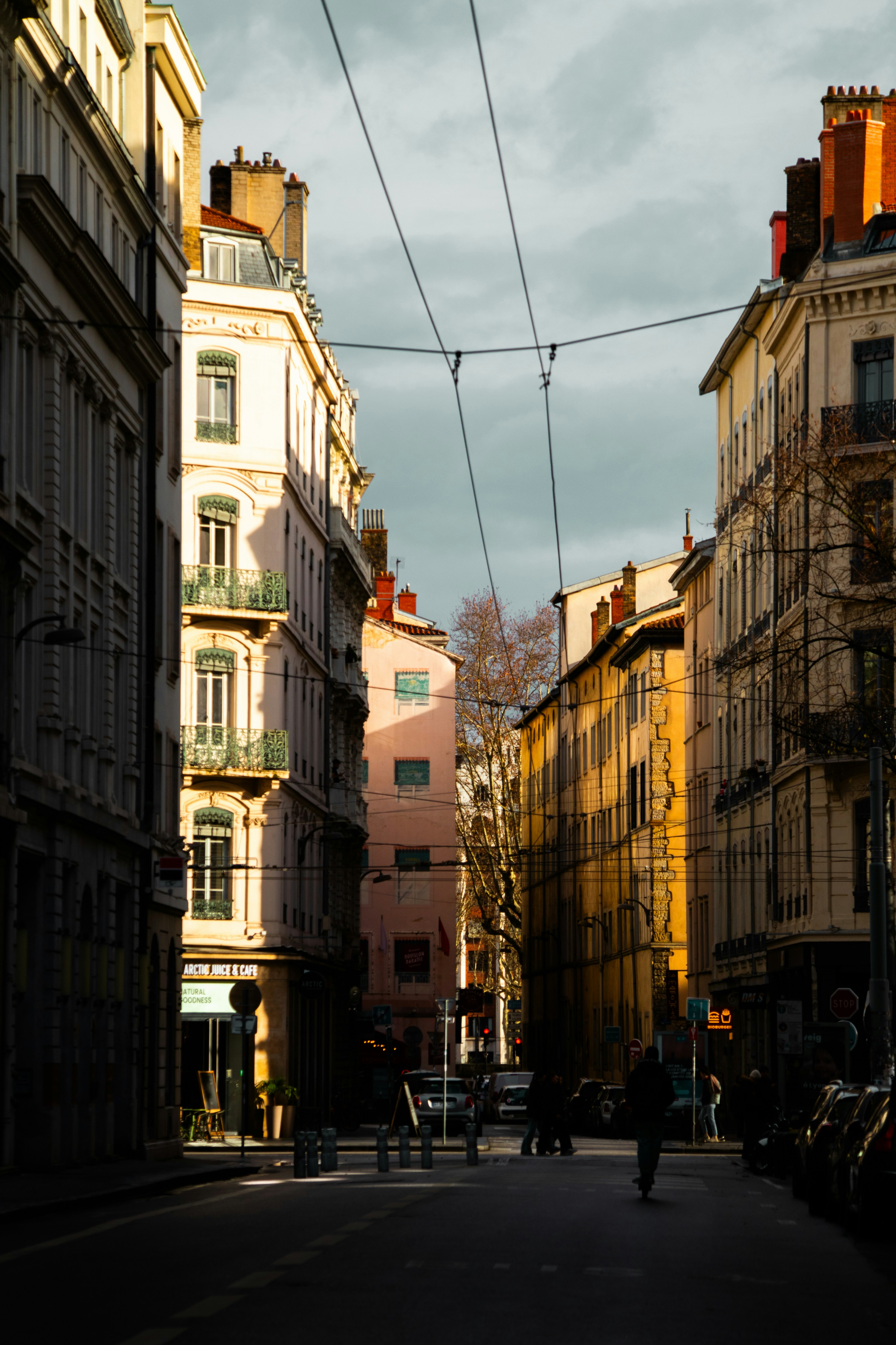 A narrow city street lined with tall buildings photo – Free City Image ...