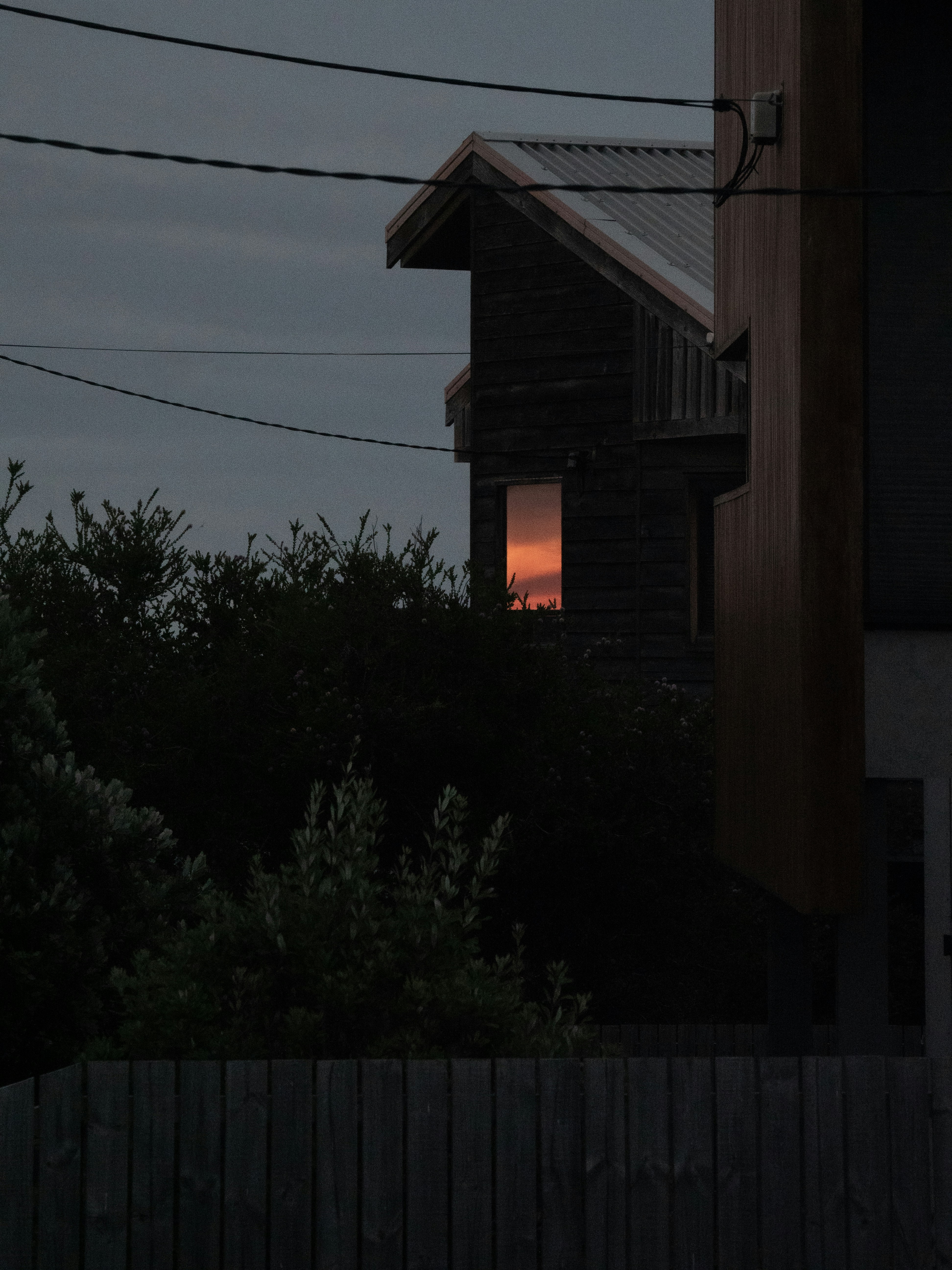 Ember Through the Gap: Sunset Glimmer in a Dark Wooden House