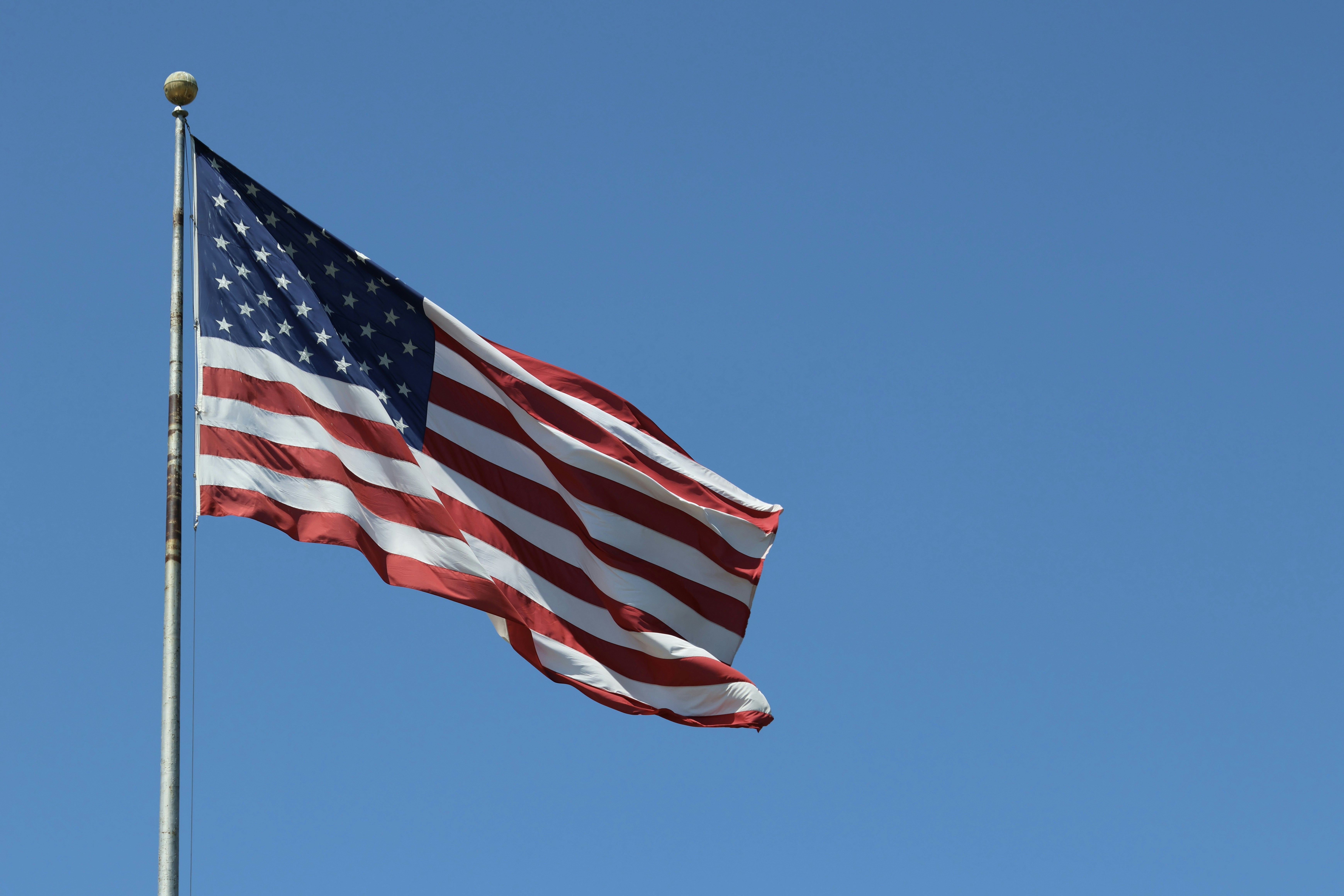 A large american flag flying in the sky photo – Free American flag ...
