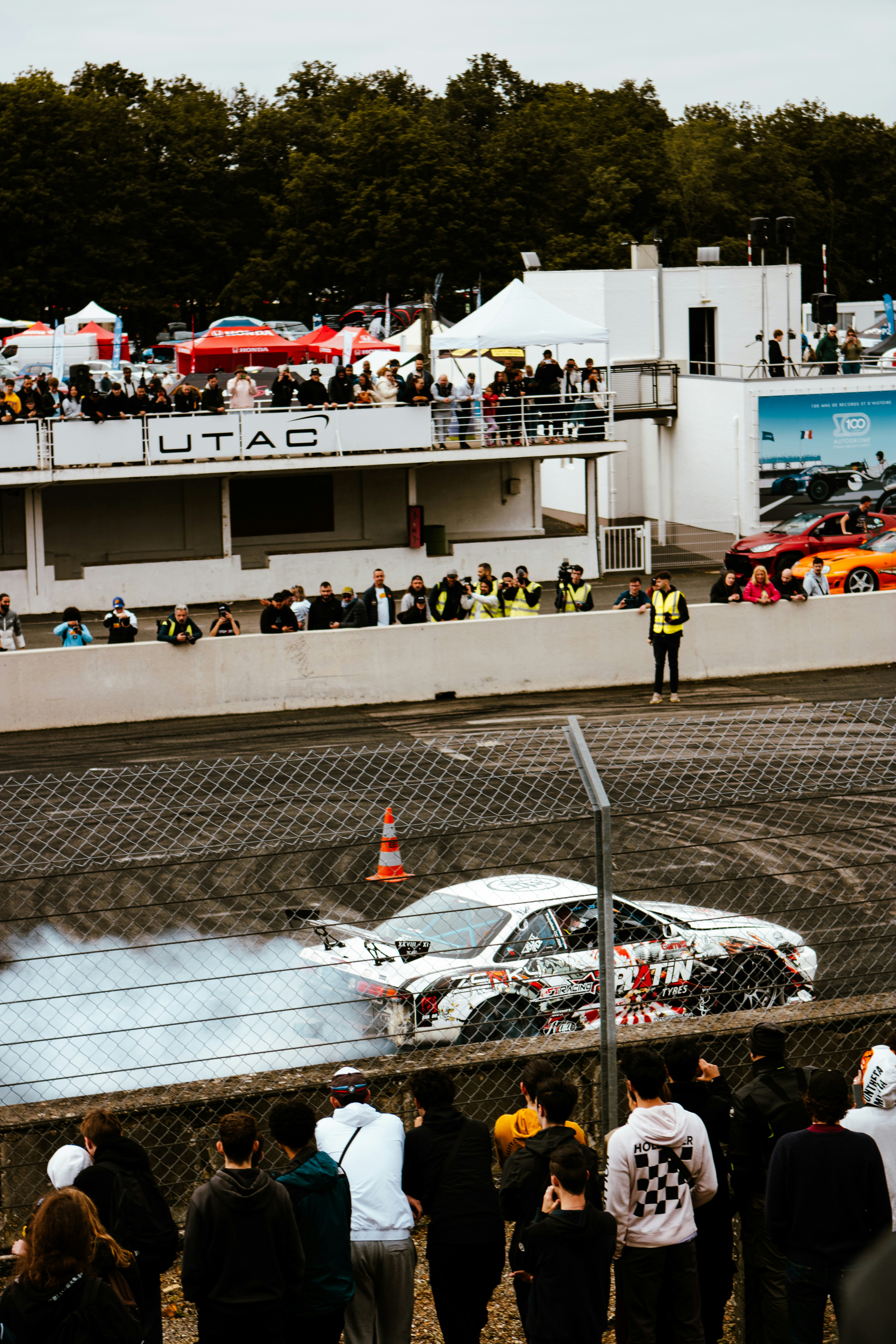 A group of people watching a car crash on a track photo – Free Car ...