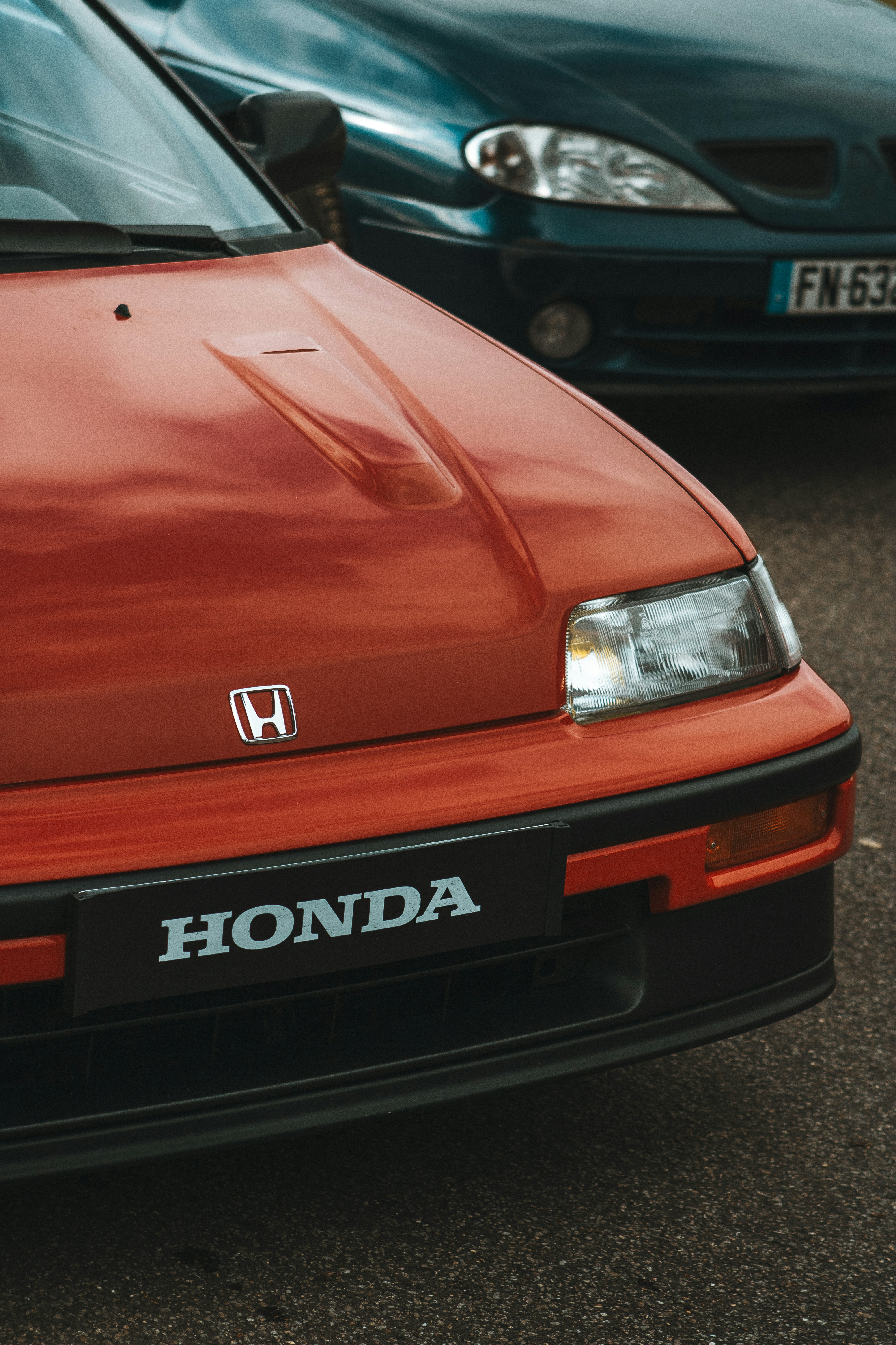 Orange Honda Front End in Focus with Teal Backdrop