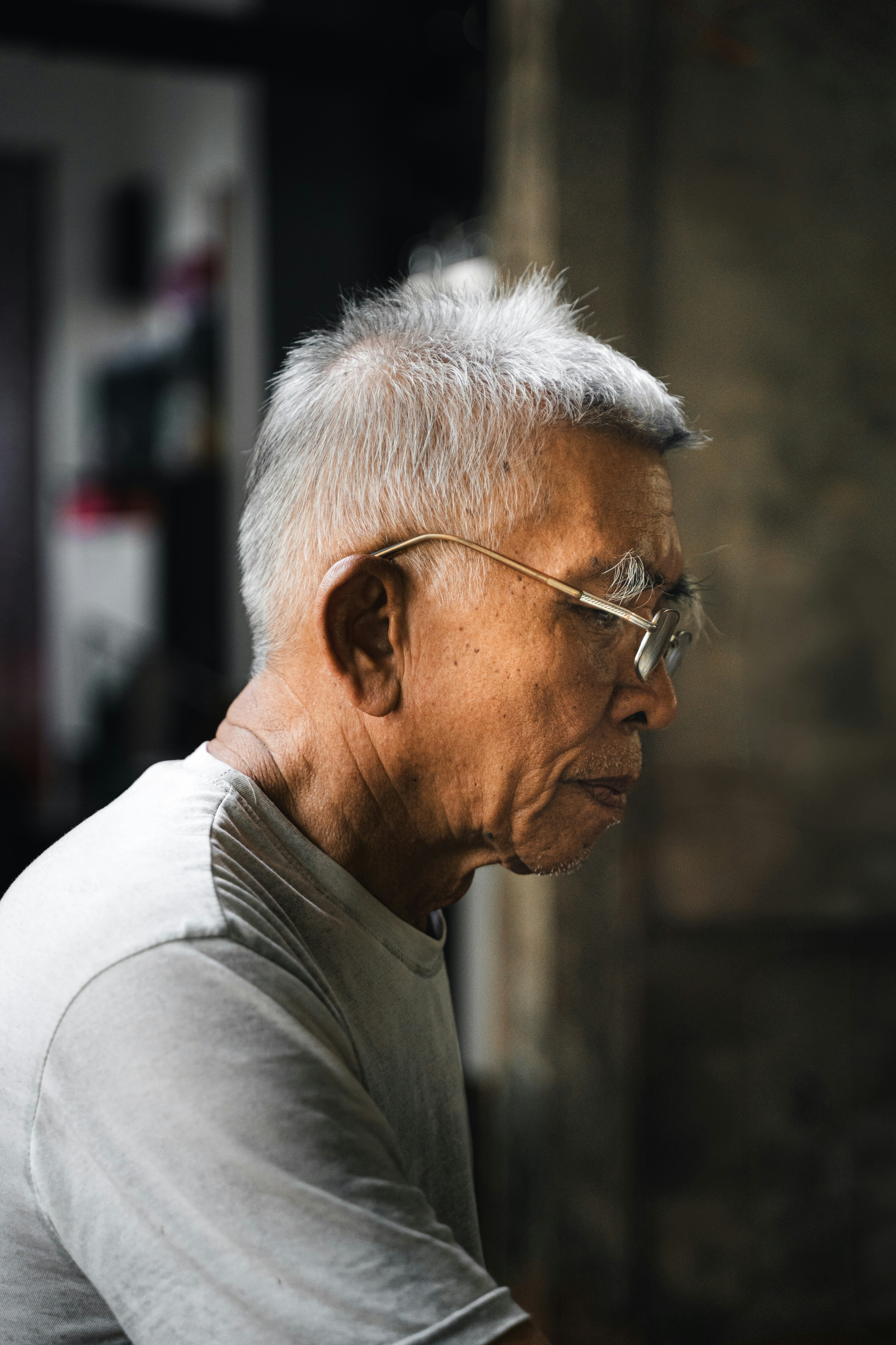 An old man with glasses is looking at something photo – Free Portrait ...