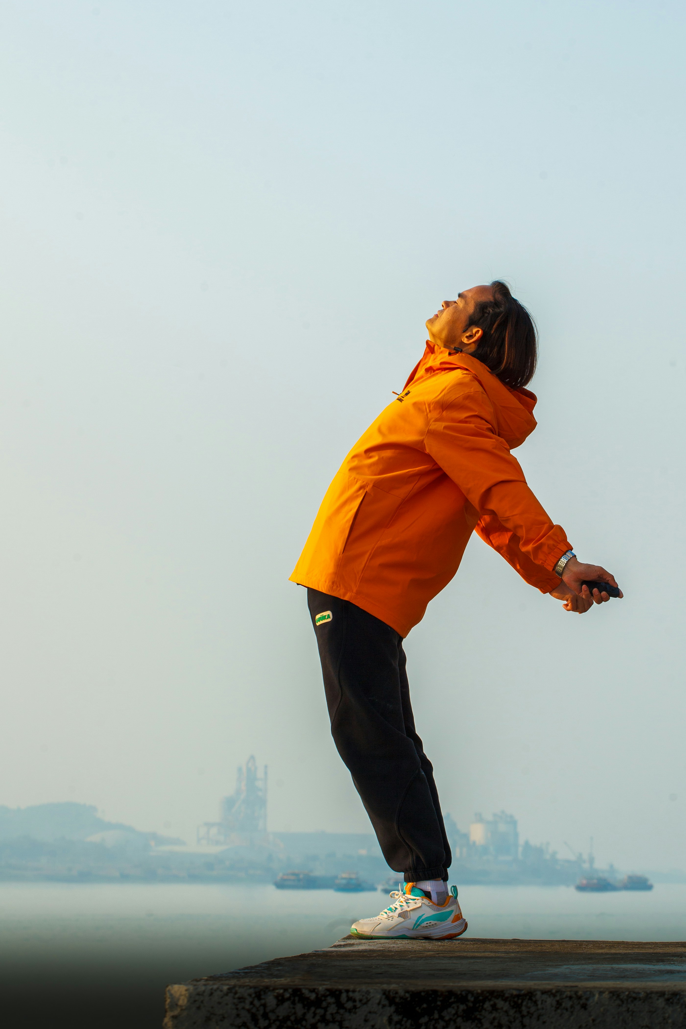 A man in an orange jacket throwing a frisbee photo – Free Coat Image on ...