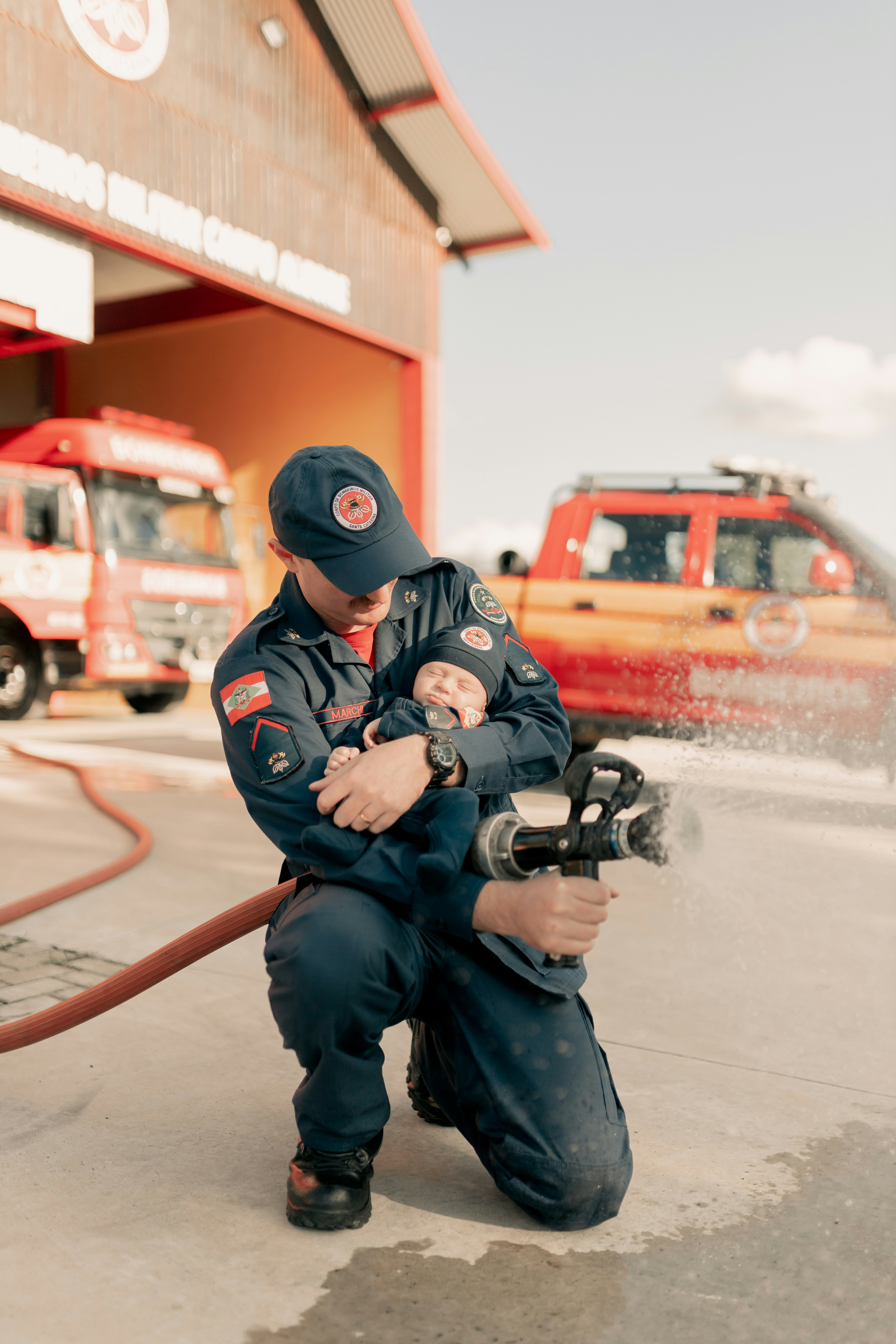 A fireman is holding a hose and spraying water on a fire hydrant photo ...