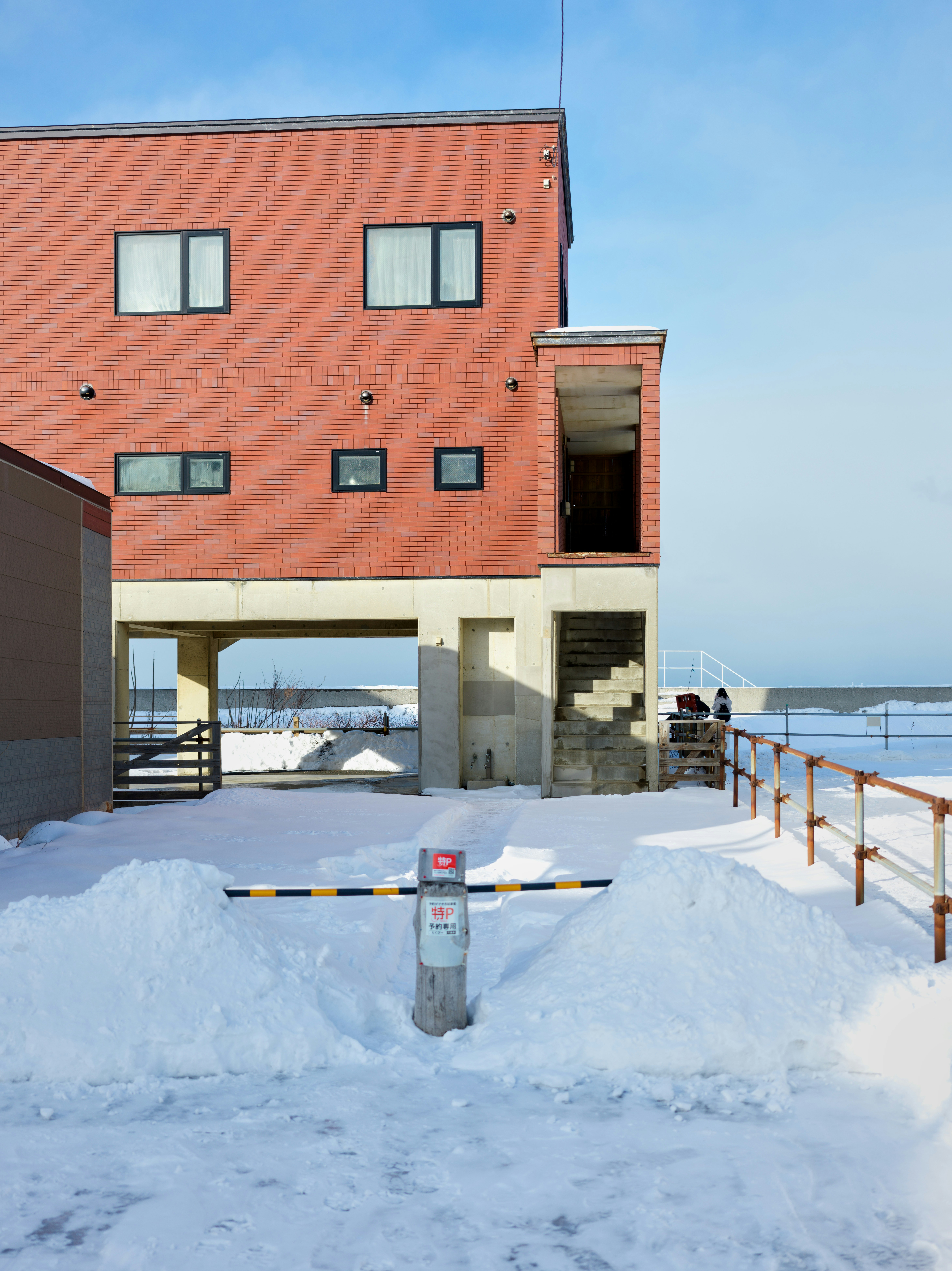 A snow covered parking lot next to a building