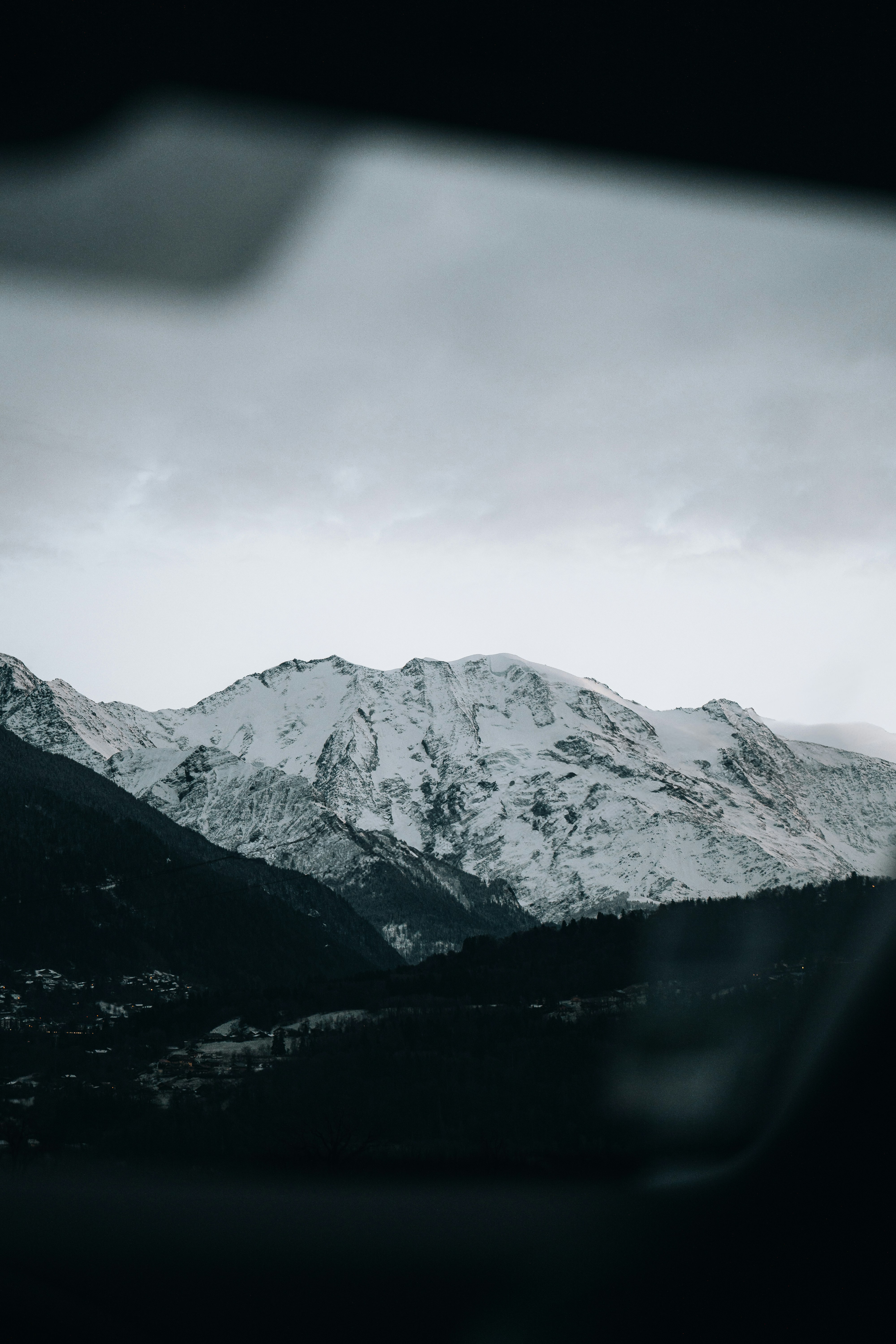 Snow-Crowned Peaks Framed by a Dim Car Window