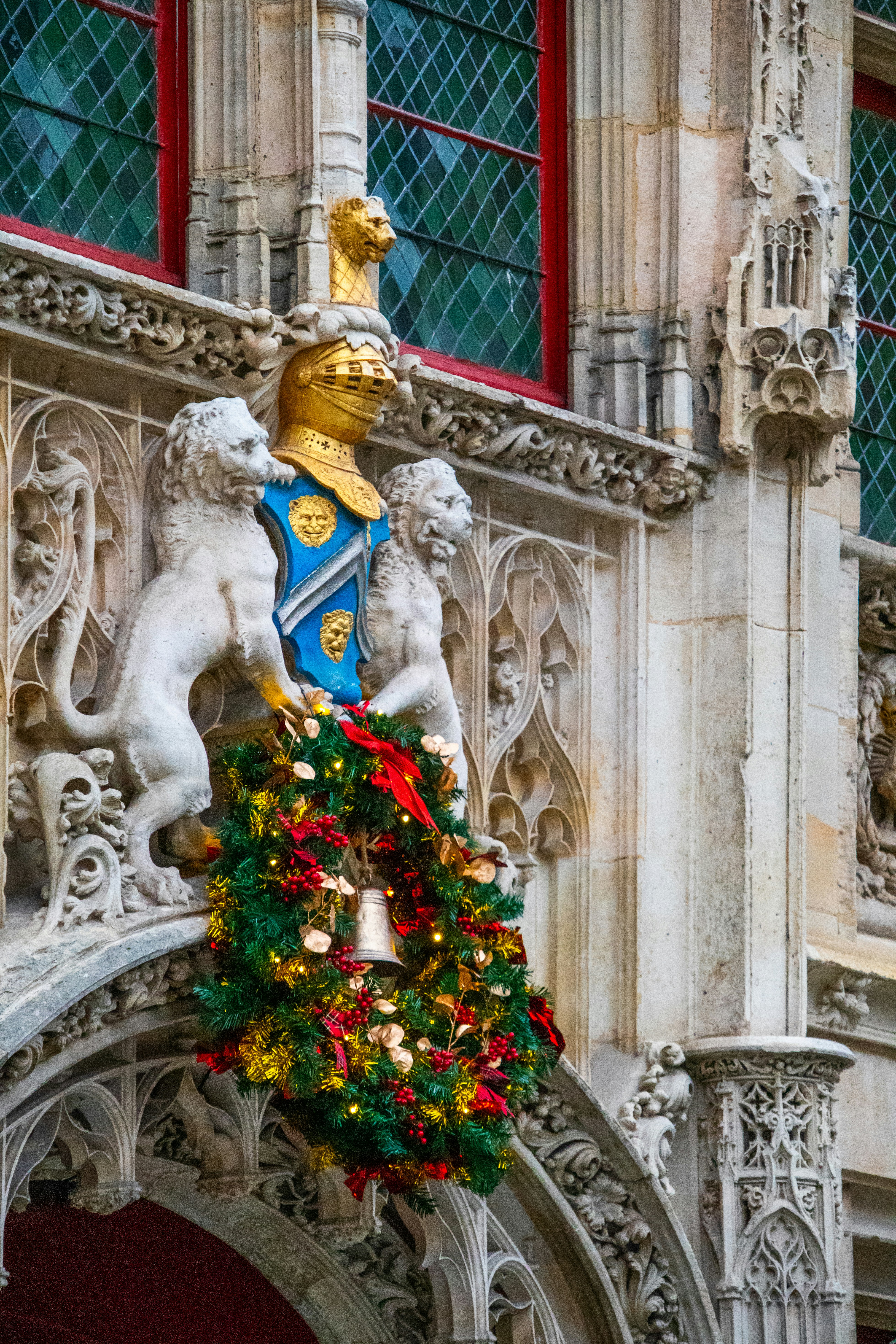 Gilded Crest Under Gothic Carvings: Lions, Shield, and a Festive Wreath