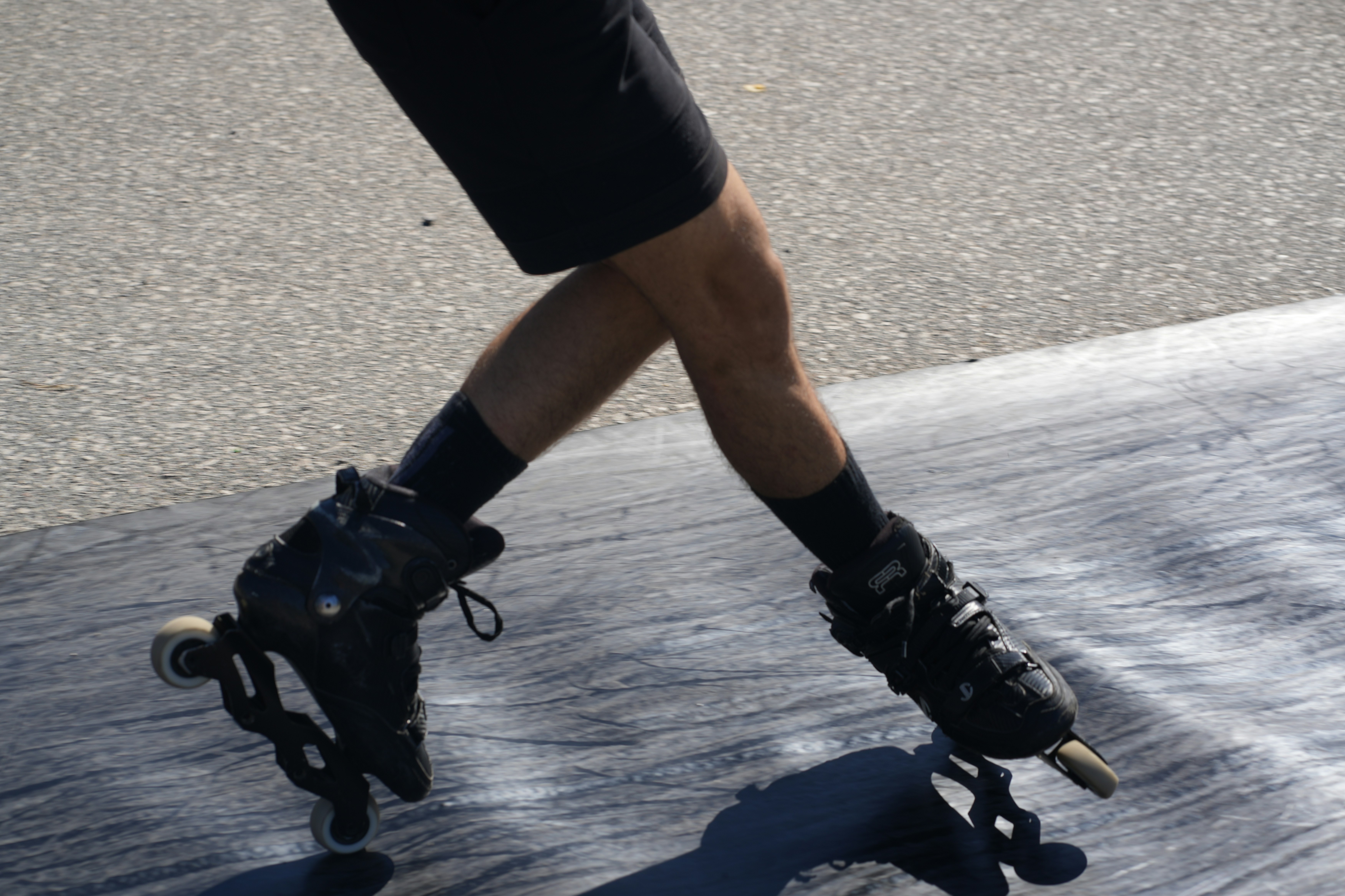 A man riding a skateboard down a street photo – Free Skating Image on ...