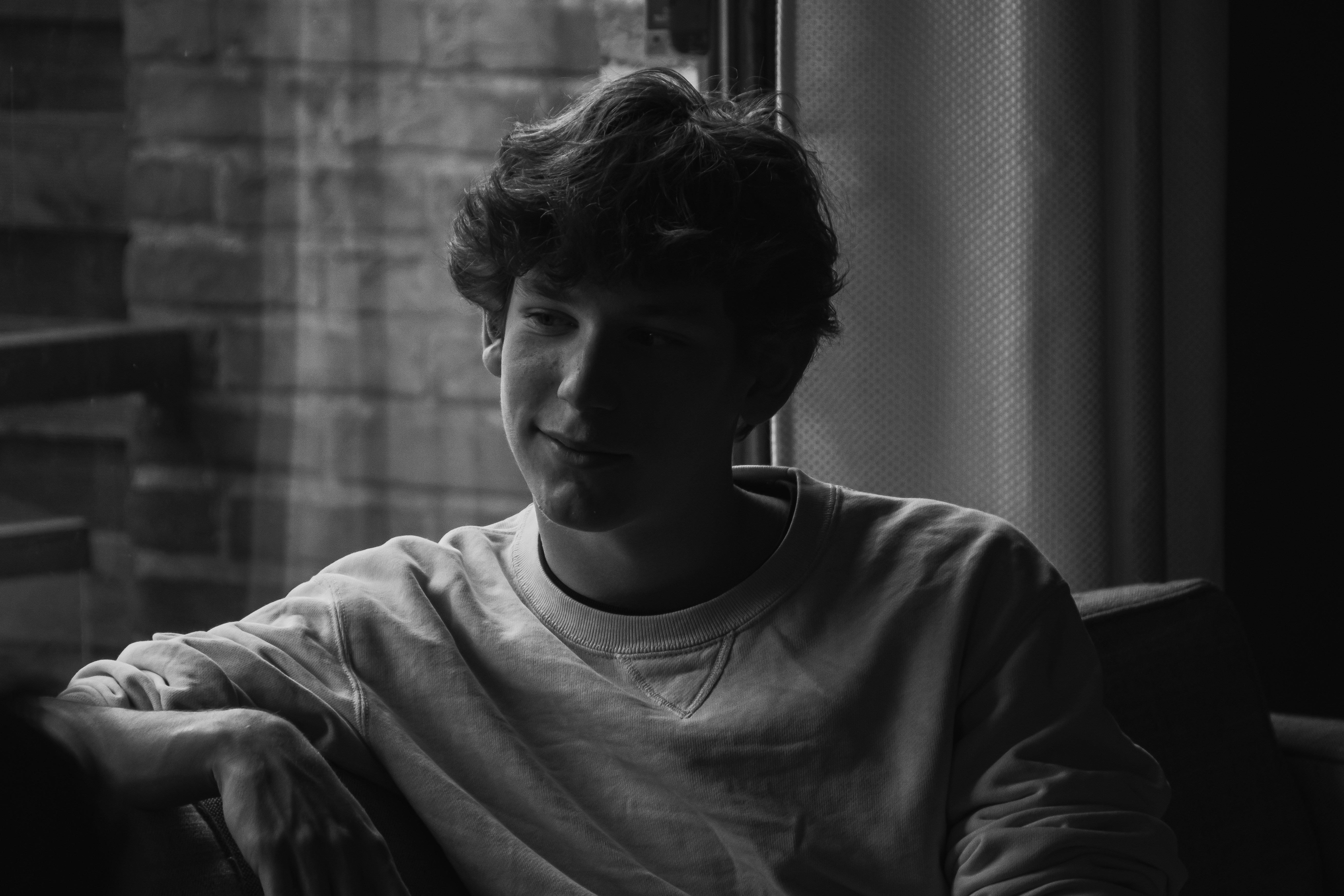 Un homme assis sur une chaise et regardant par la fenêtre photo – Image ...