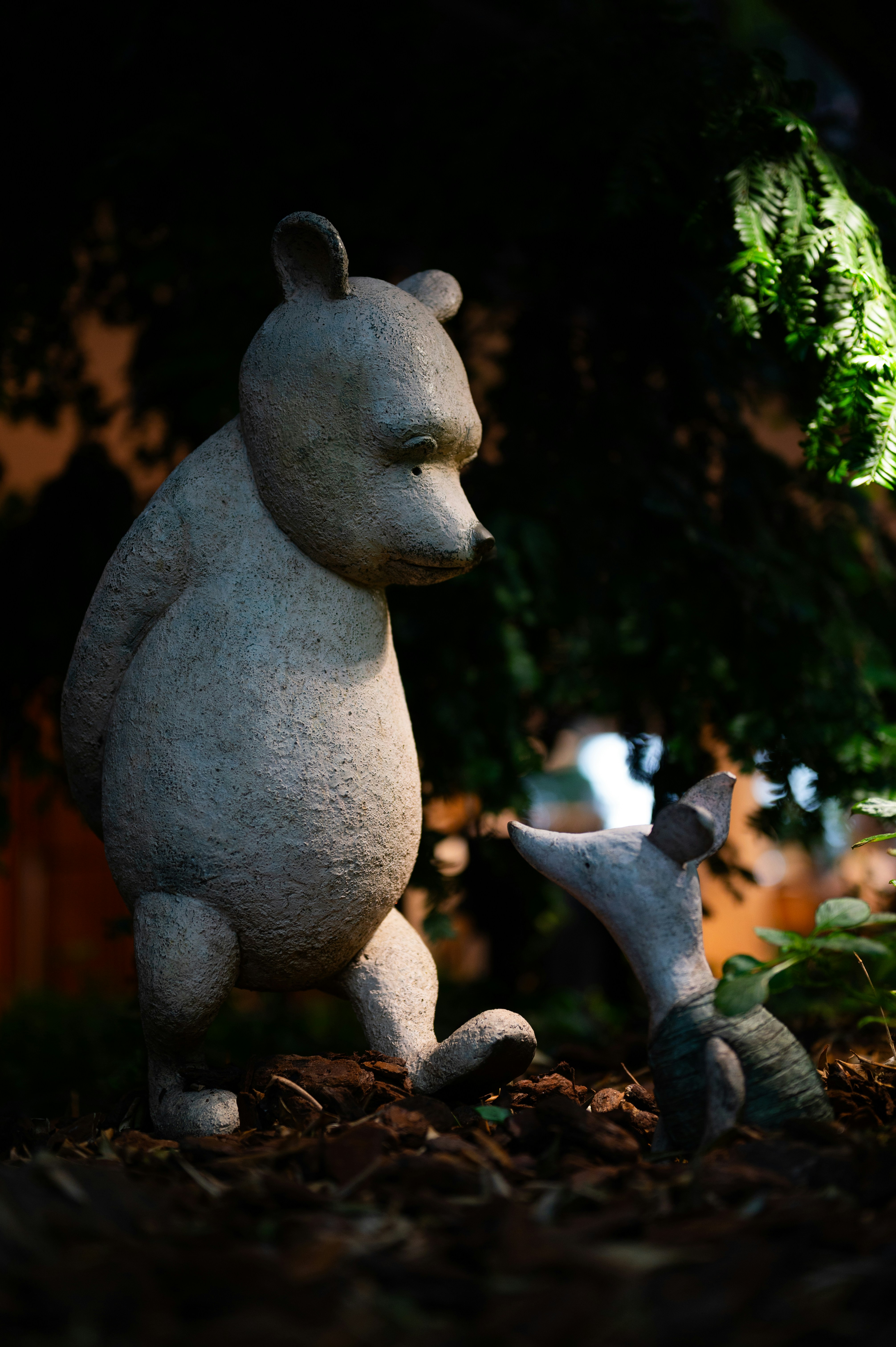 Moonlit Companions: A Stone Bear and a Playful Fox in the Garden