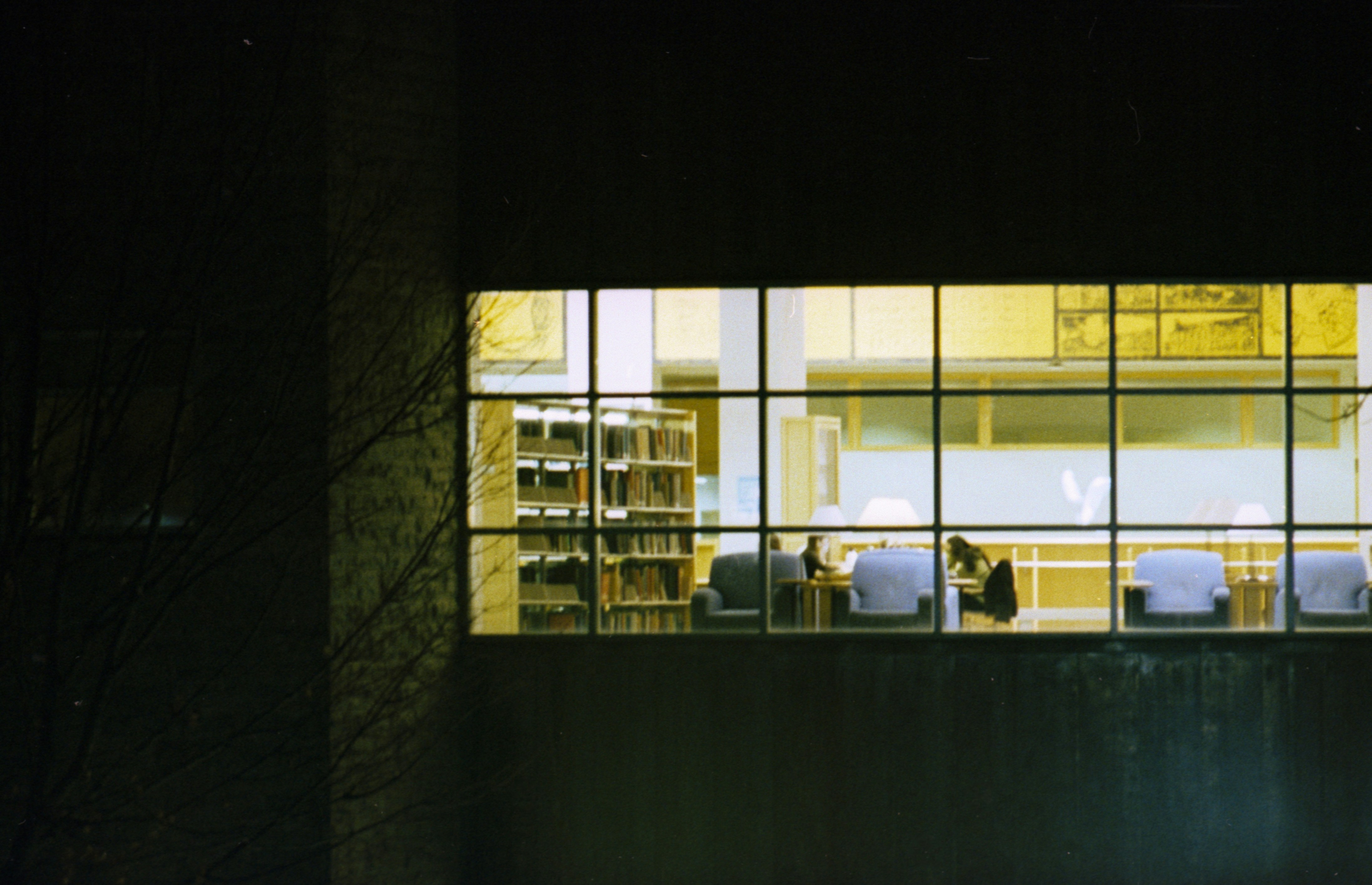 A view of a building through a window at night photo – Free Film ...