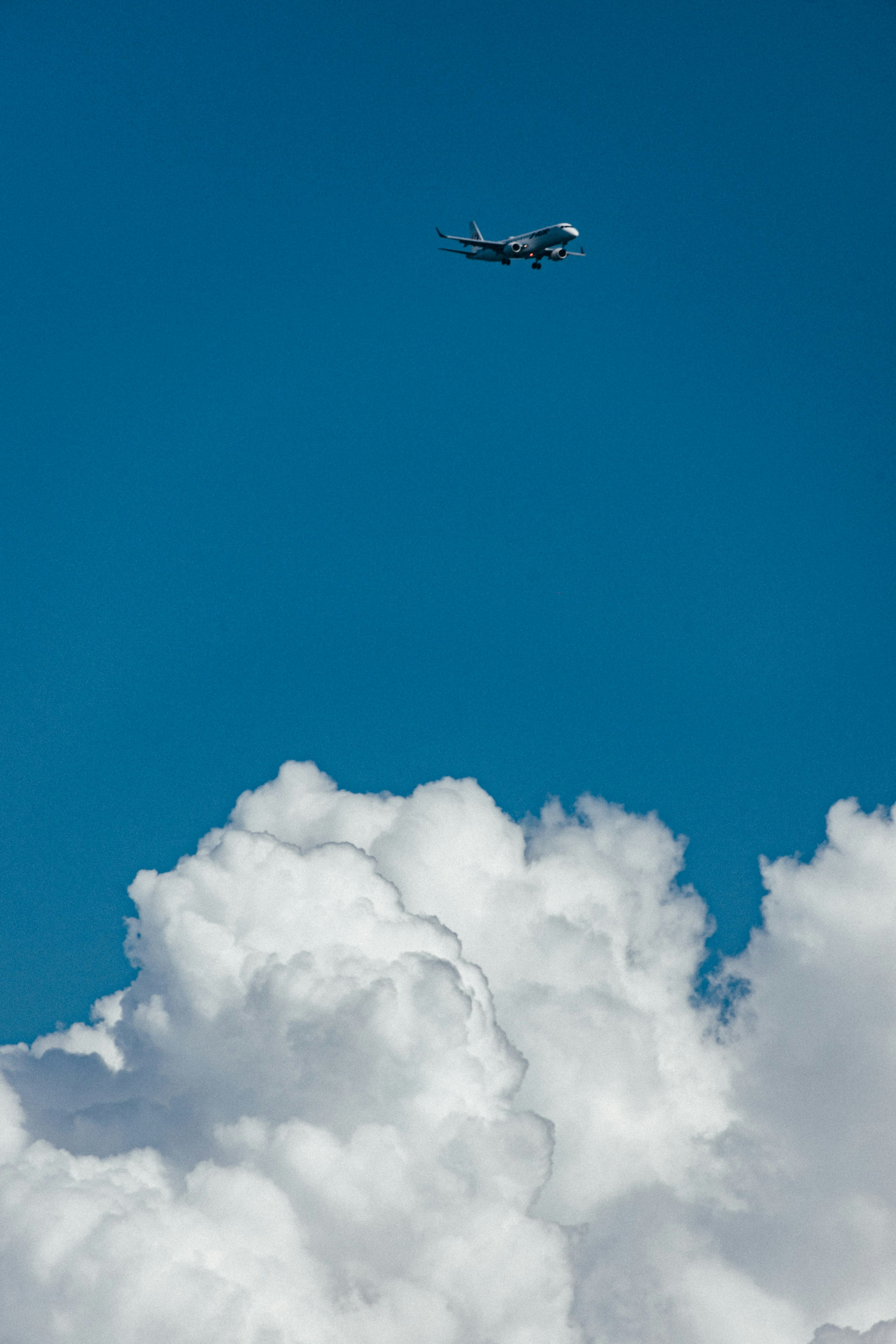 An airplane is flying high in the sky photo – Free Sky Image on Unsplash