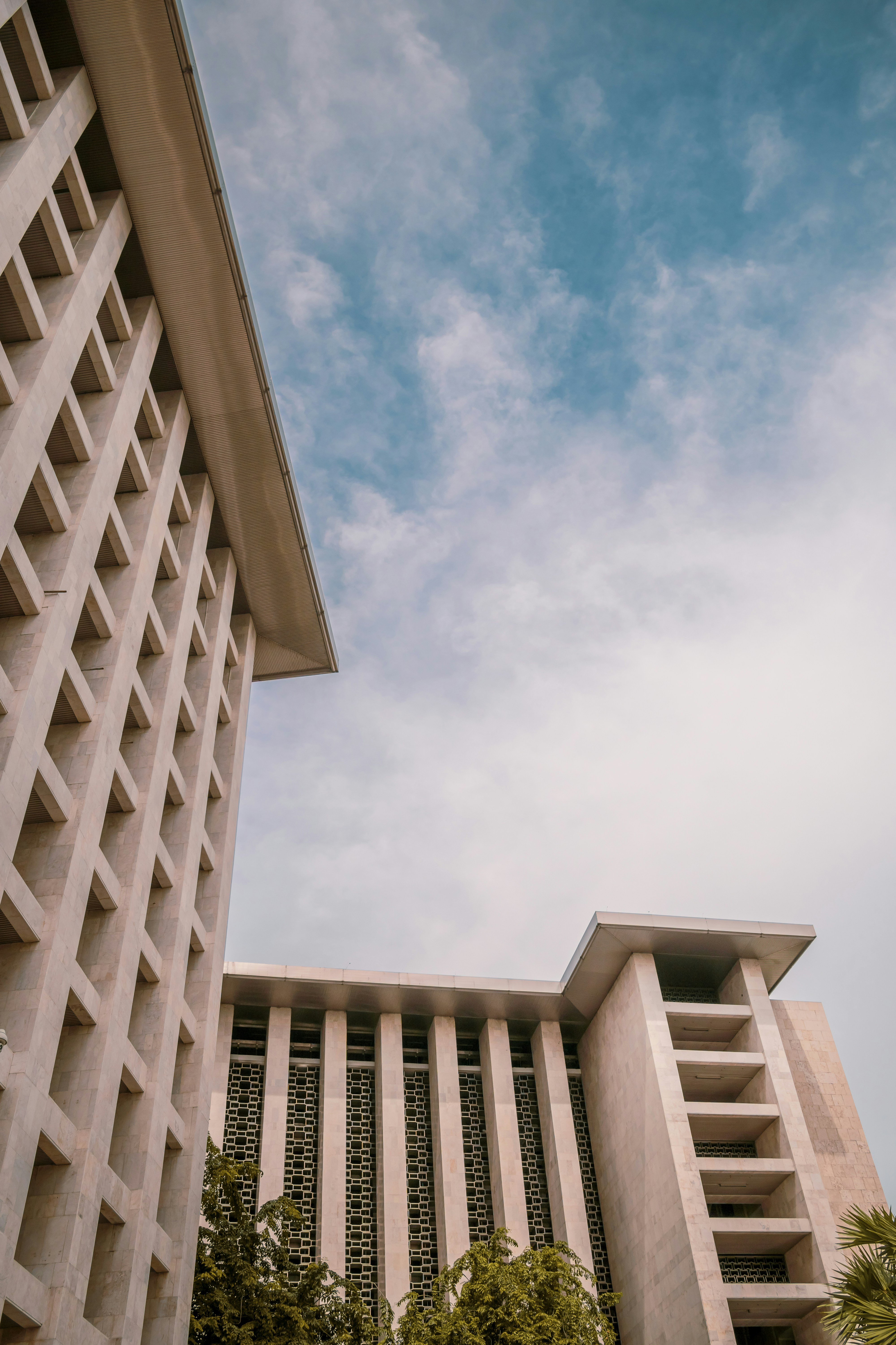 A tall building sitting next to another tall building photo – Free ...