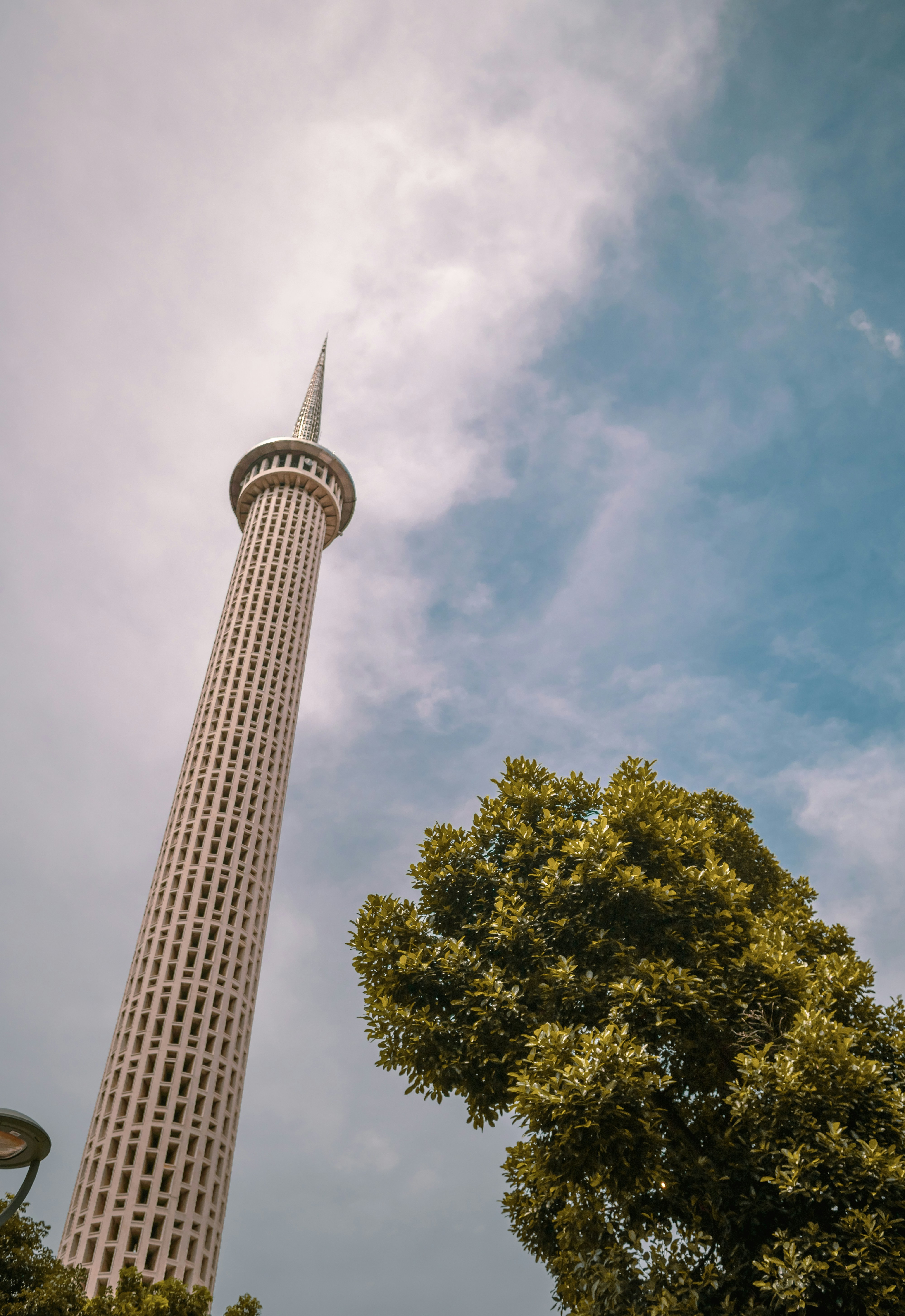 A tall tower towering over a lush green forest photo – Free ...