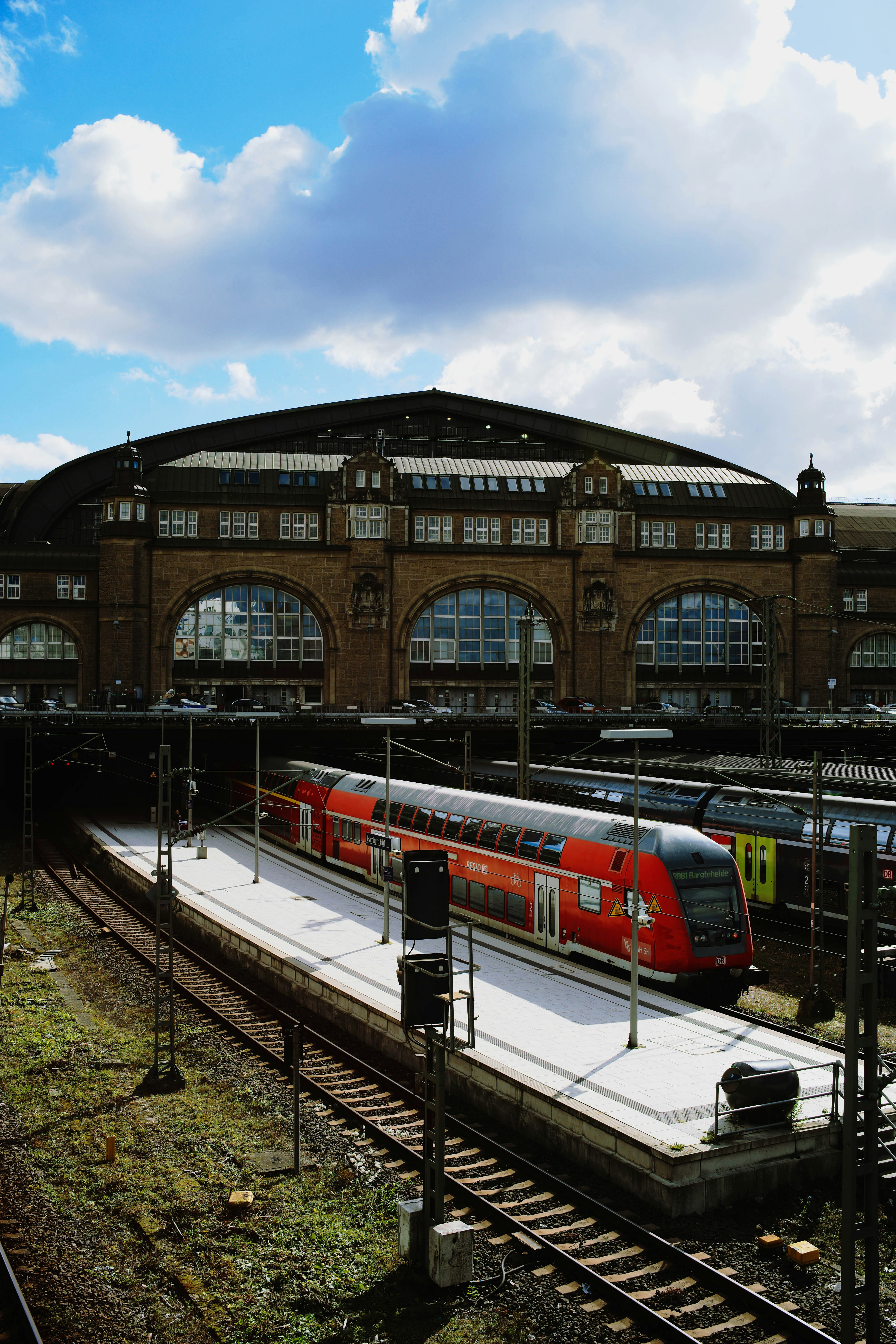 Ein rot-weißer Zug, der an einem Bahnhof vorbeifährt Foto – Kostenloses ...