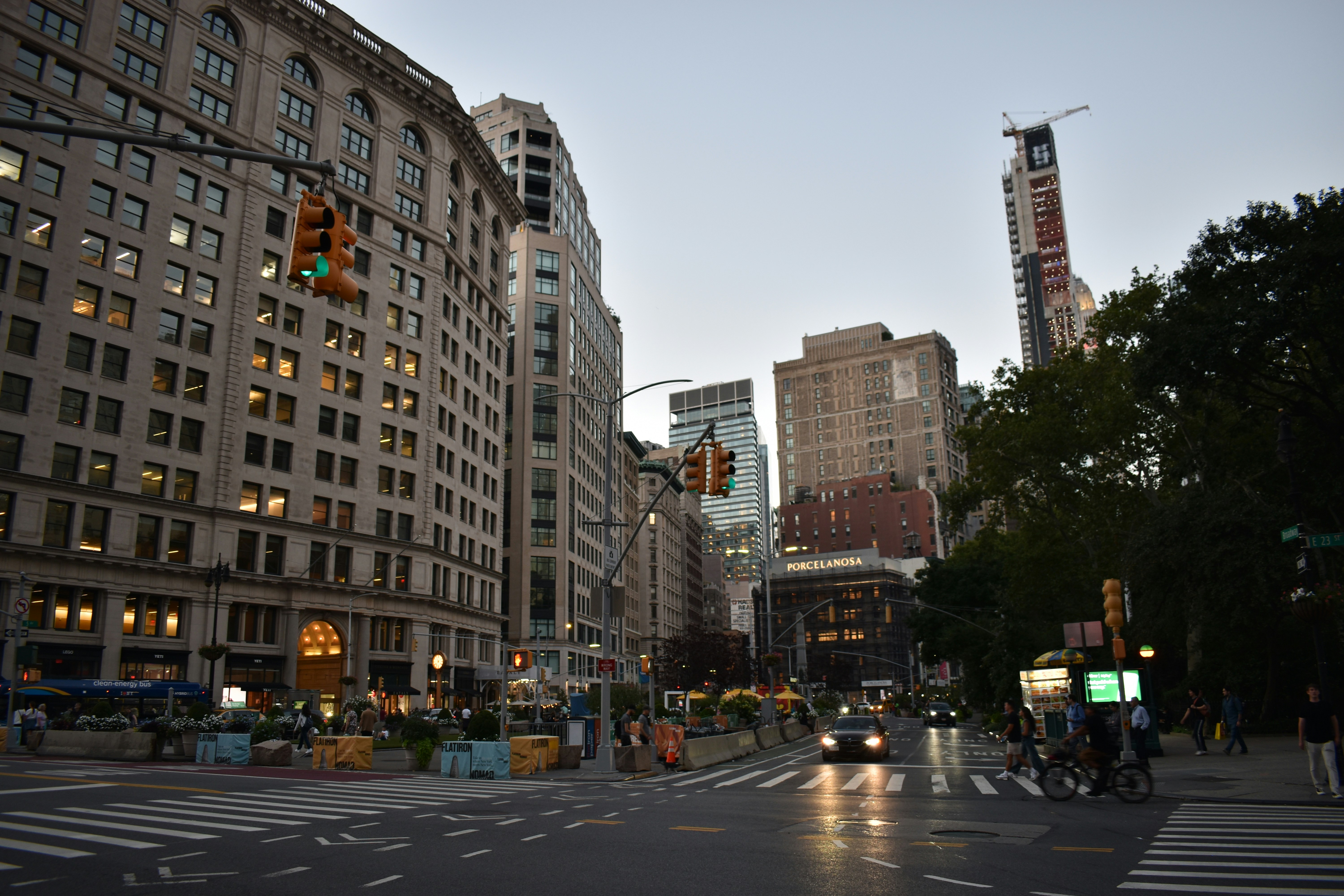 Dusk at the Crosswalk: Neon Echoes Between Brick Towers