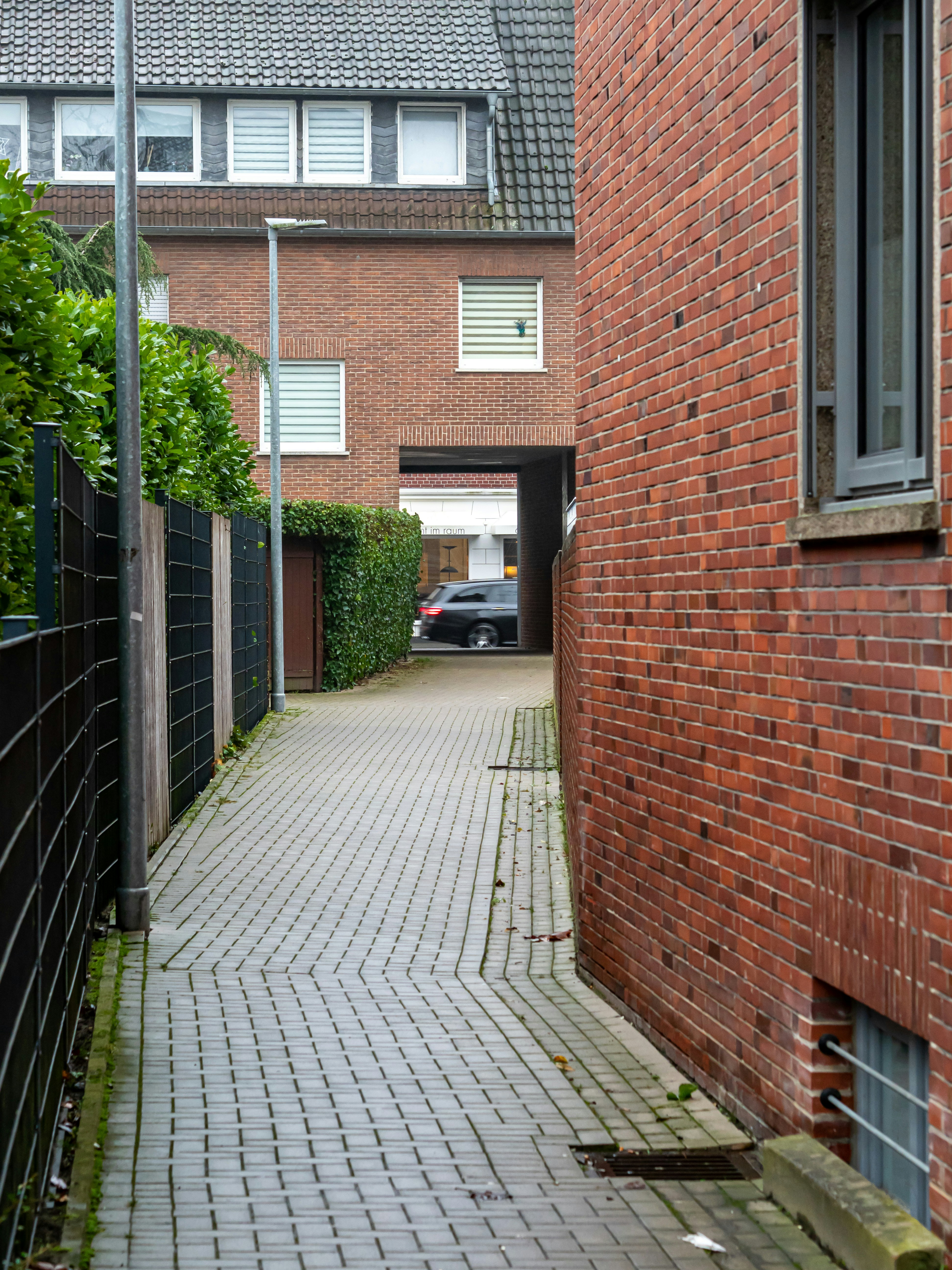 A brick walkway between two brick buildings photo – Free City Image on ...