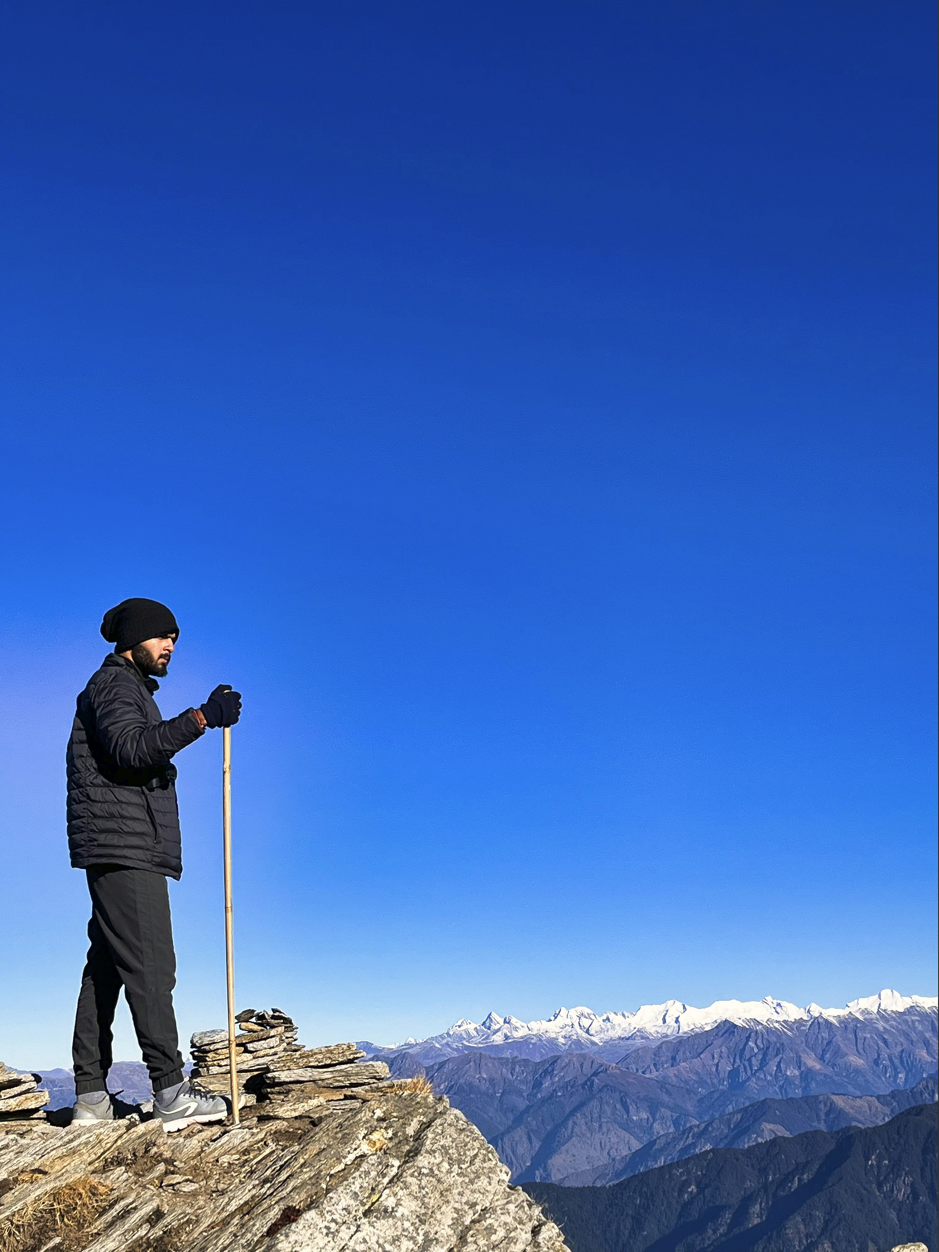 Lone climber on a ridgeline beneath a cobalt sky