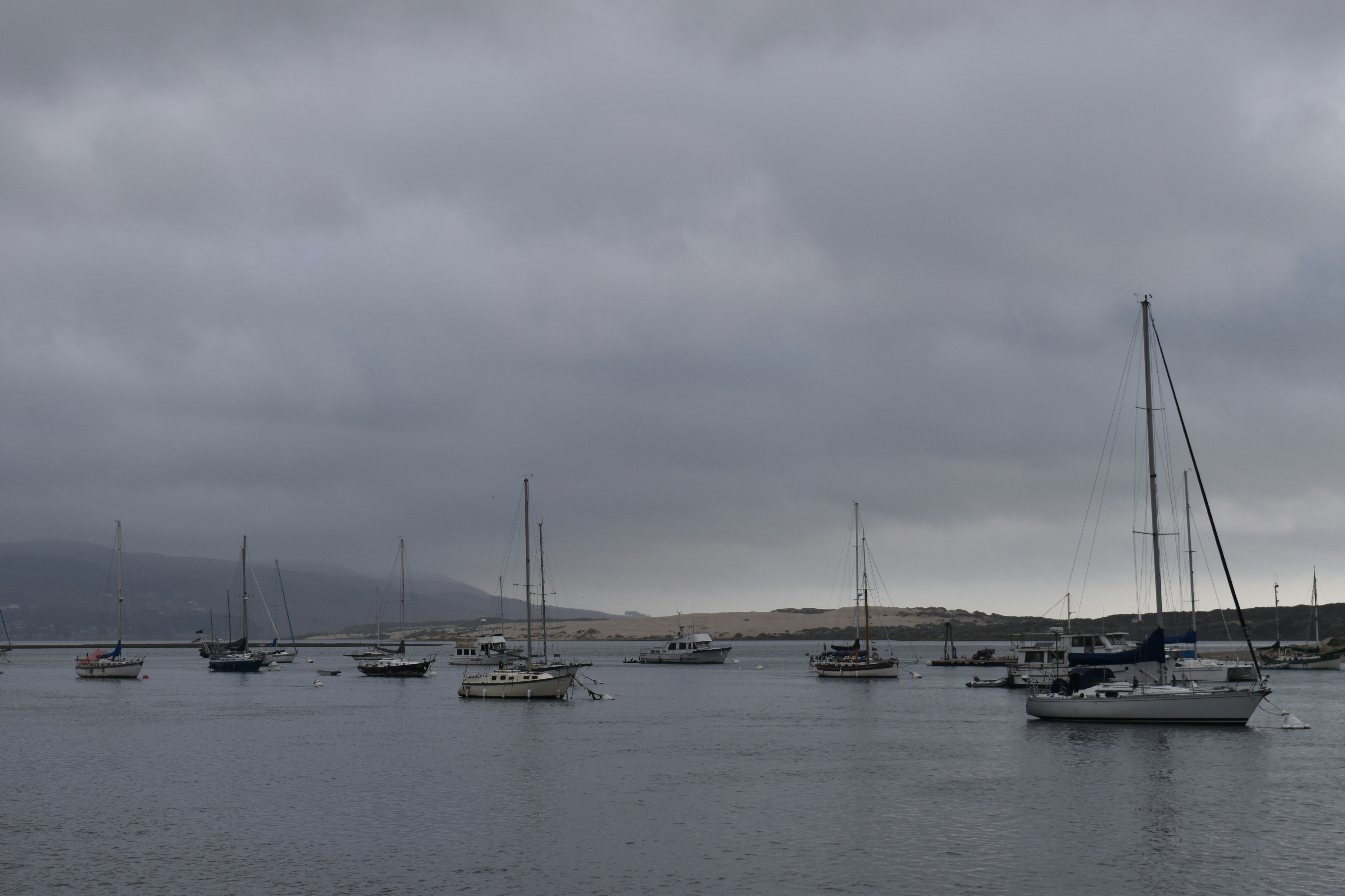 Leaden Harbor: Sailboats Rest Along a Quiet Channel Under Gray Skies