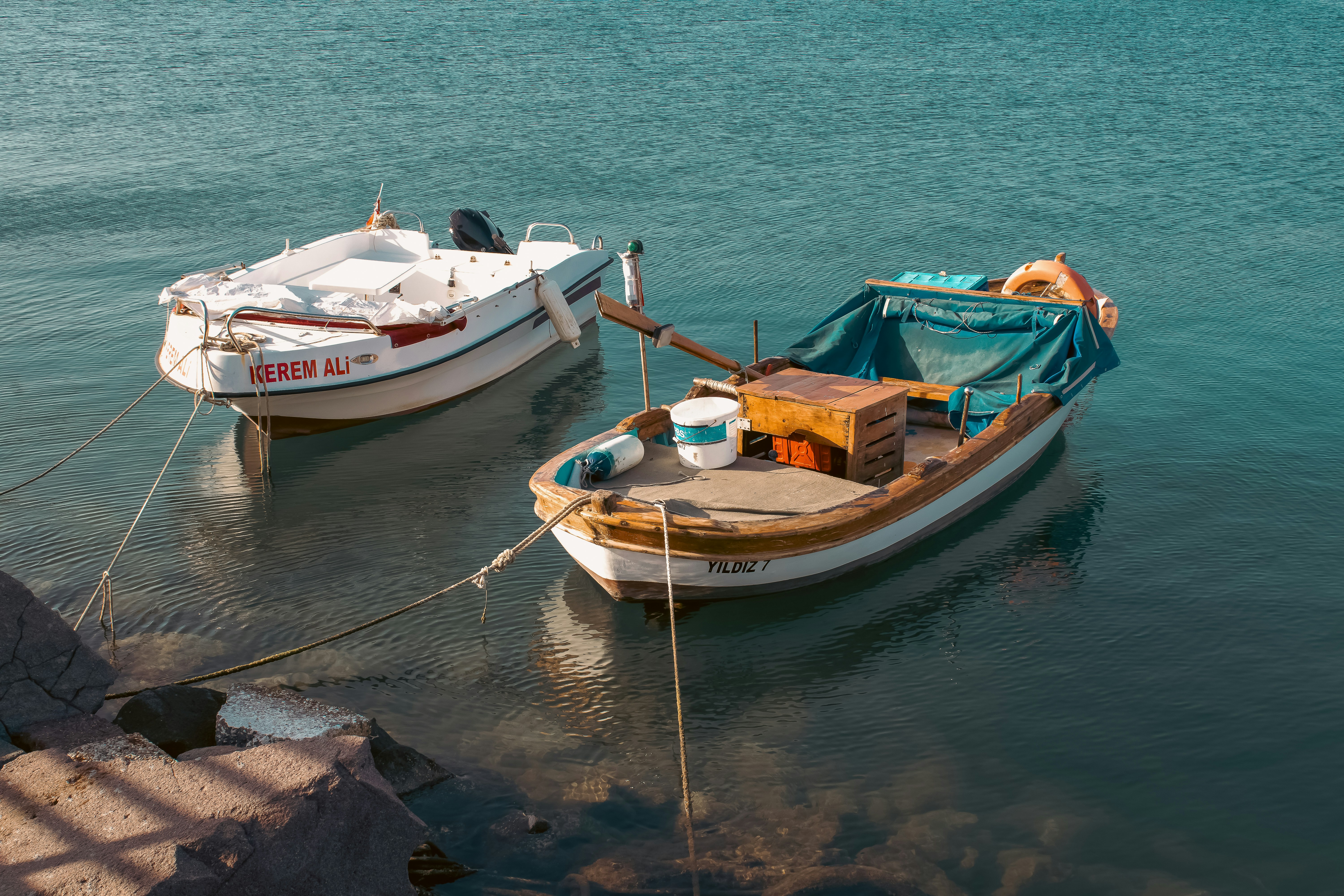 Un par de botes que están sentados en el agua foto – Imagen de Foça ...