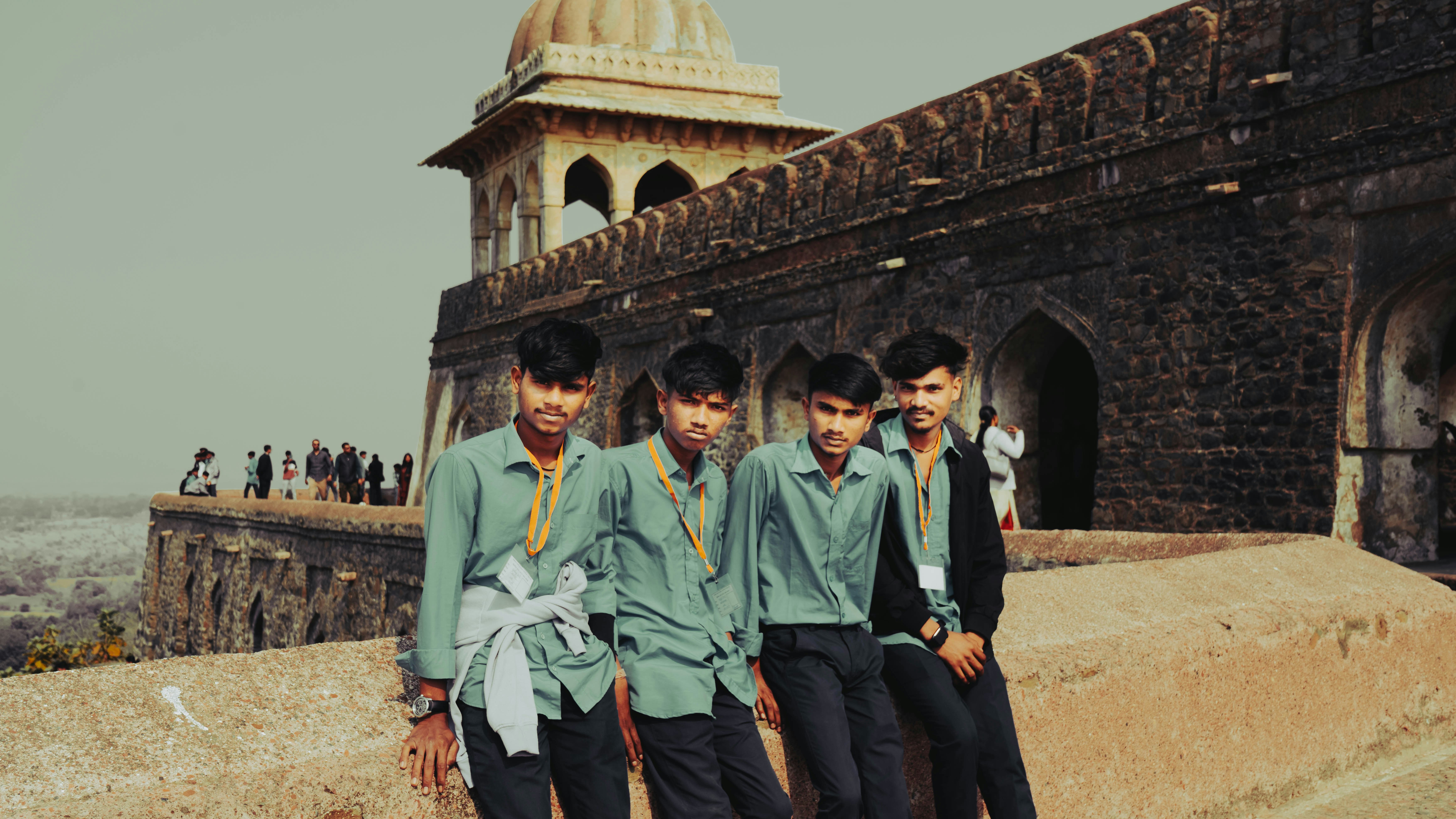 Quartet by the Fort: Teal Shirts Along the Sea Wall