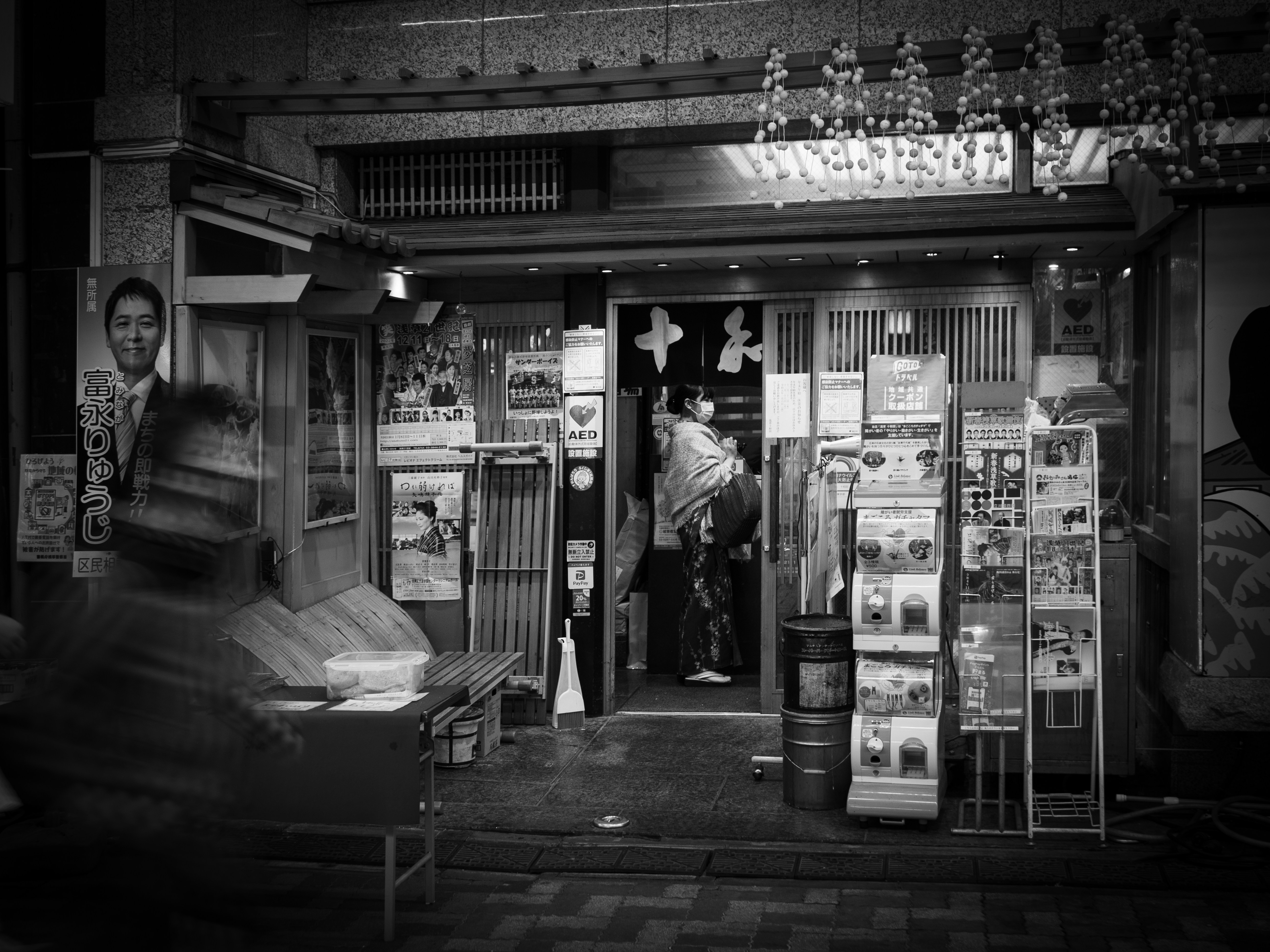 Monochrome Threshold: A Quiet Moment at a Busy Streetfront Shop