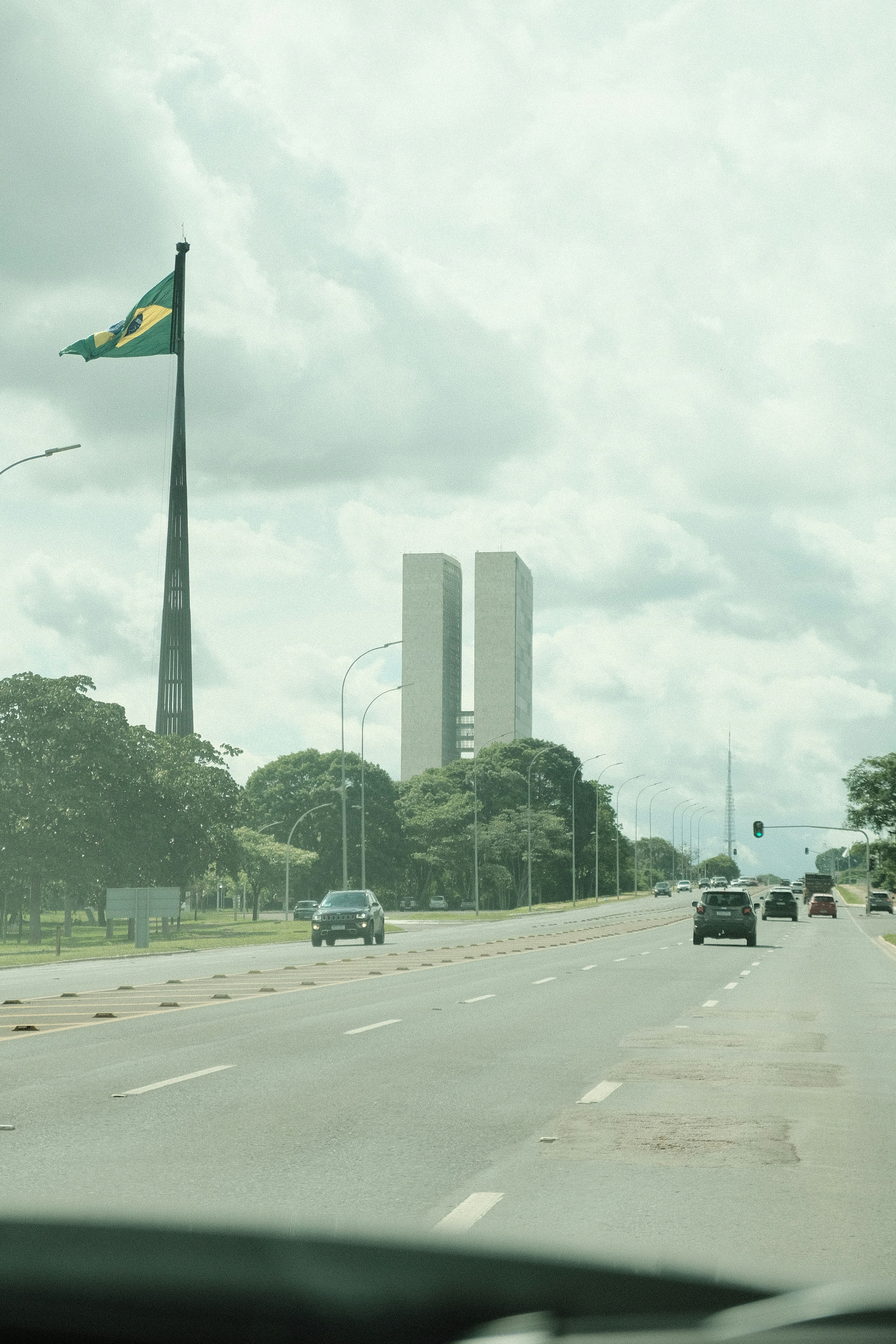 Flagpole over Brasília Boulevard: Quiet Drive Toward Twin Monoliths