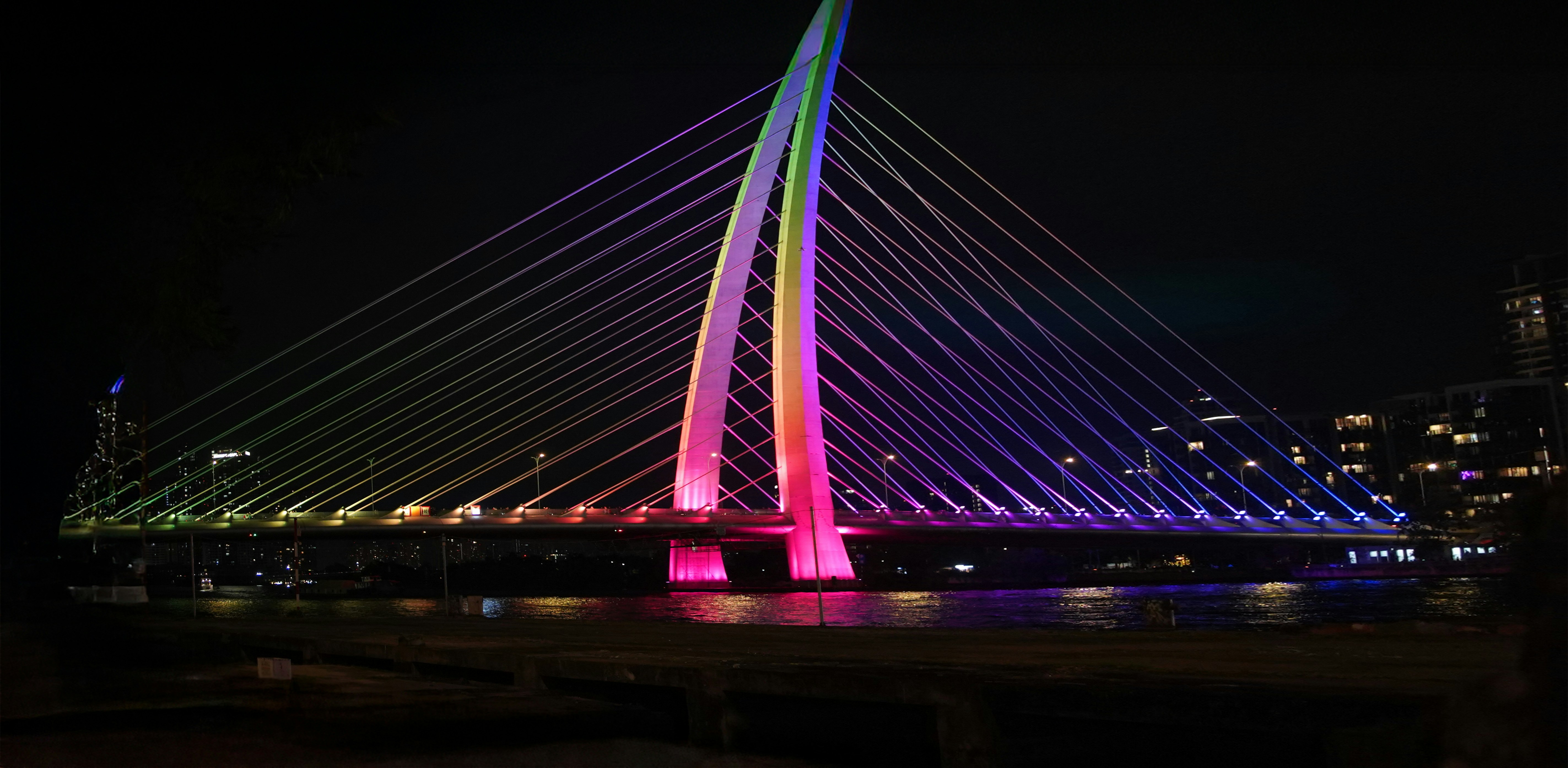 A colorful bridge lit up in the night sky photo – Free At night Image ...