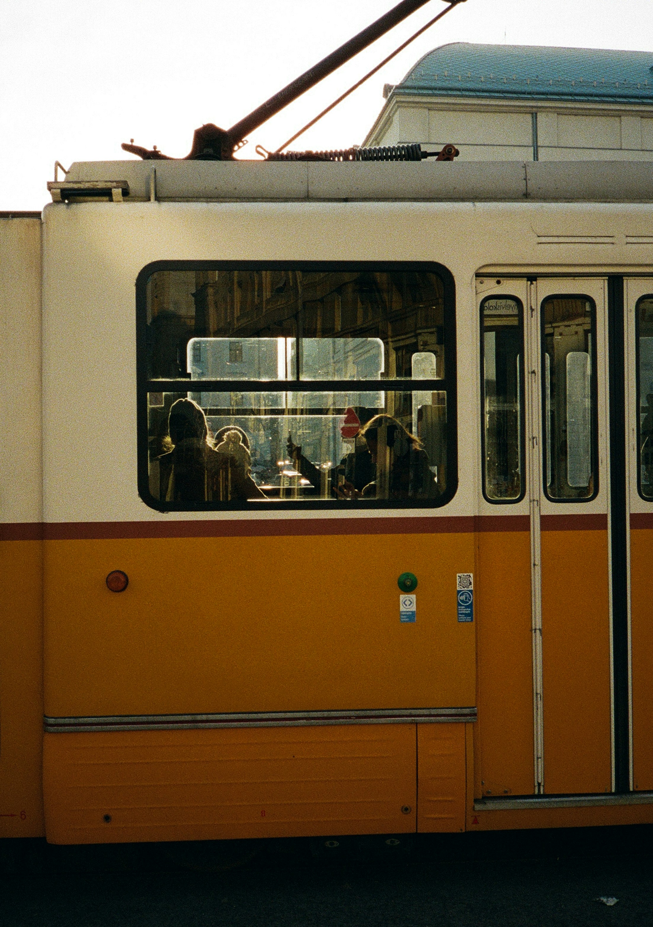 A yellow and white train car with people on it photo – Free Woman Image ...