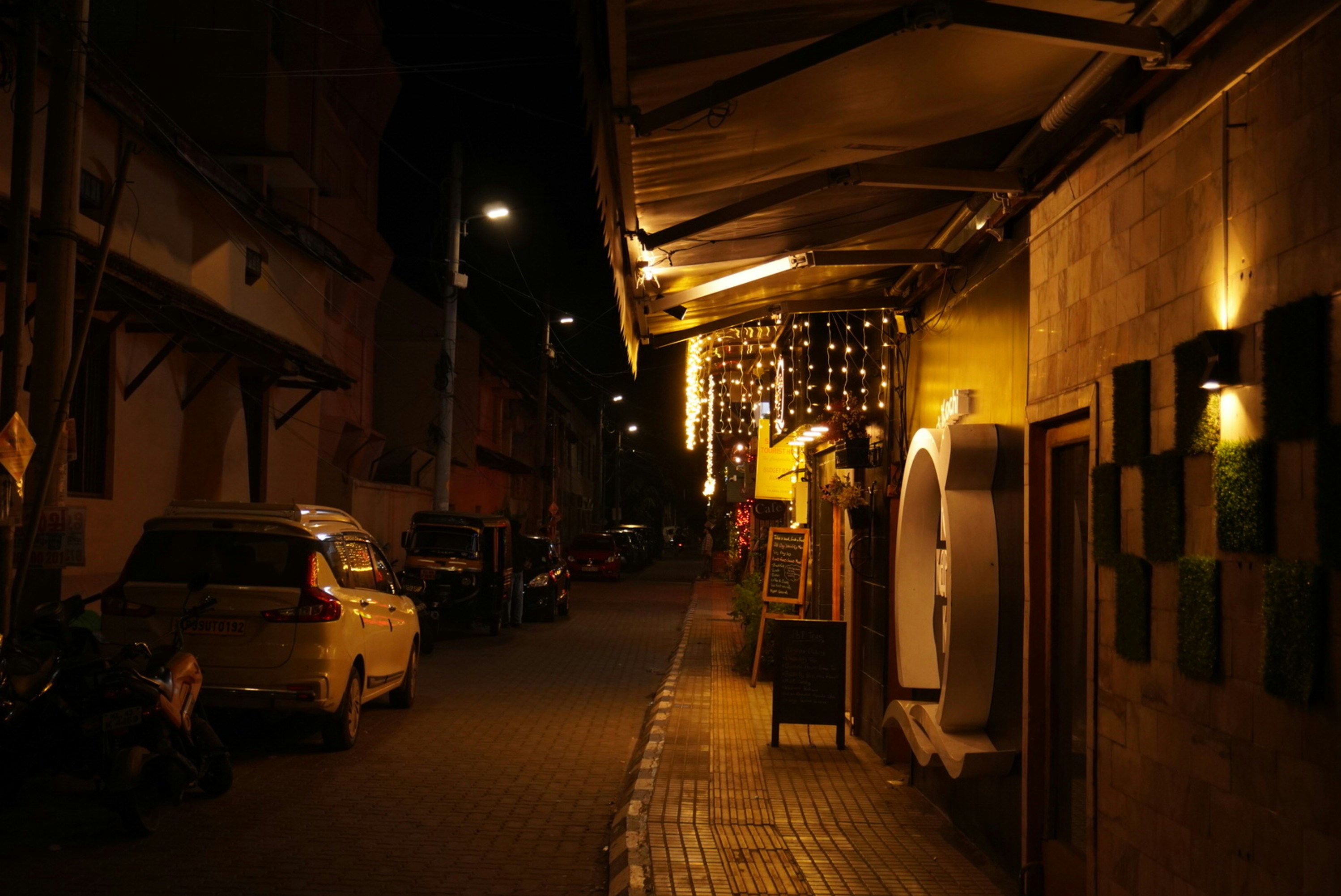 Dimly lit street adorned with warm lights, showcasing a cozy atmosphere in the heart of the city at night.